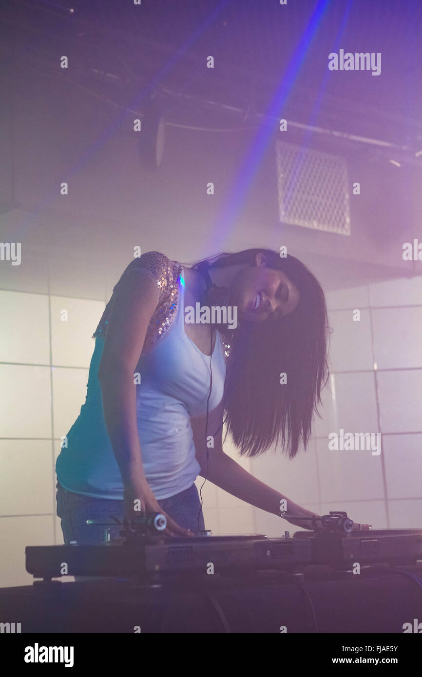Pretty female DJ playing music Stock Photo - Alamy