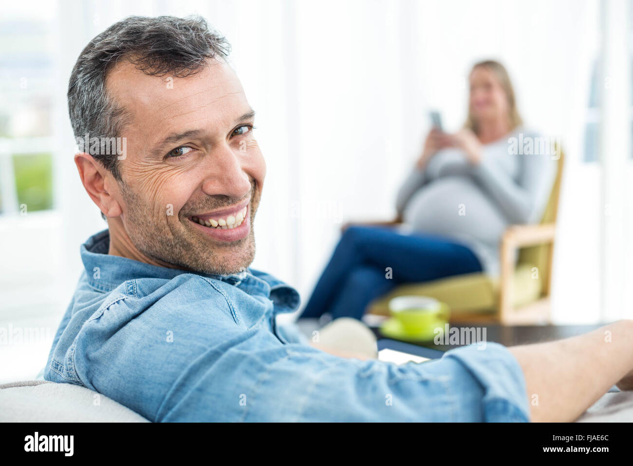 Man sitting on sofa Stock Photo - Alamy