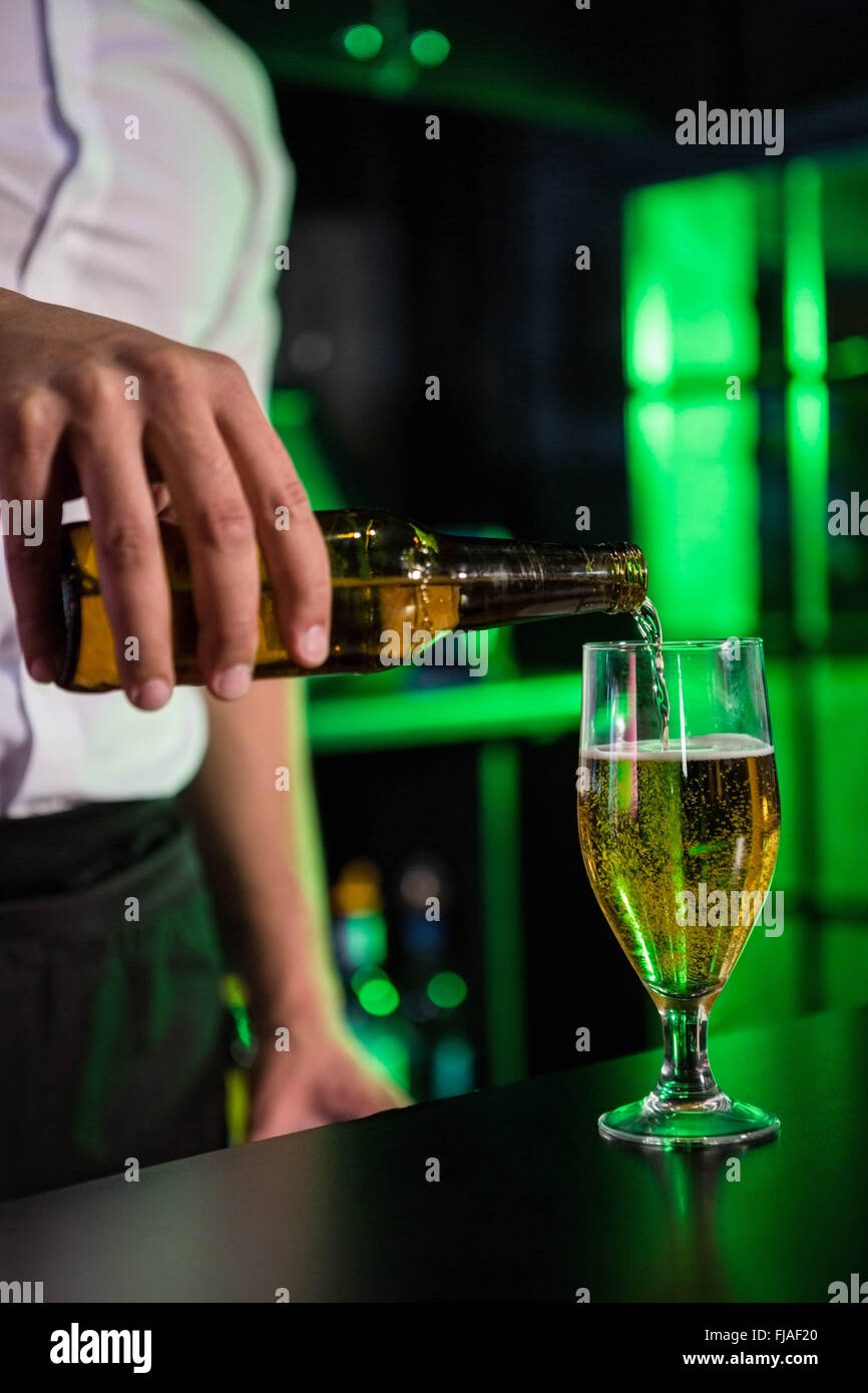 Mid section of bartender pouring beer in a glass Stock Photo - Alamy