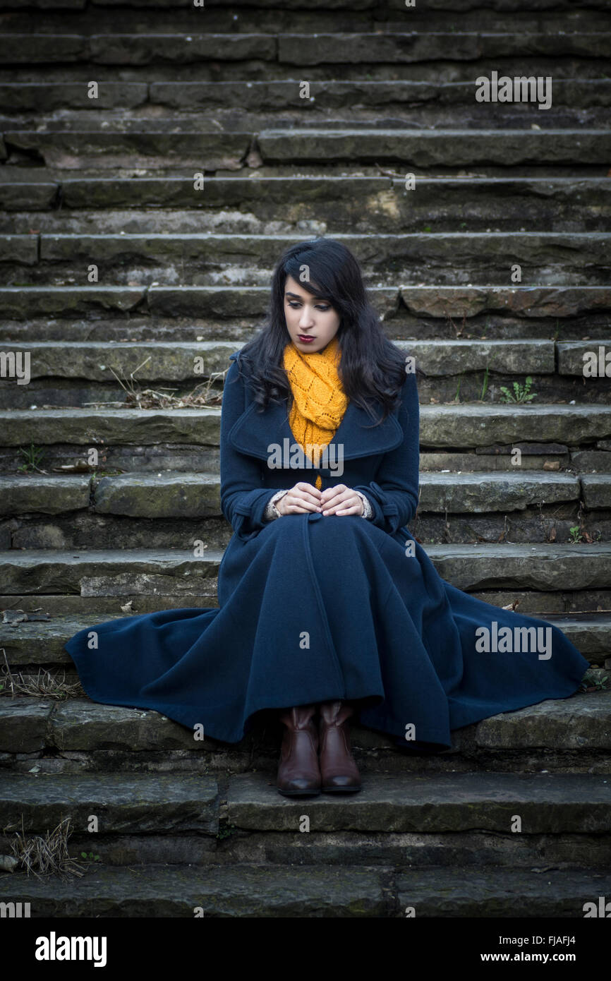 Young woman sat on the stairs outdoors Stock Photo - Alamy