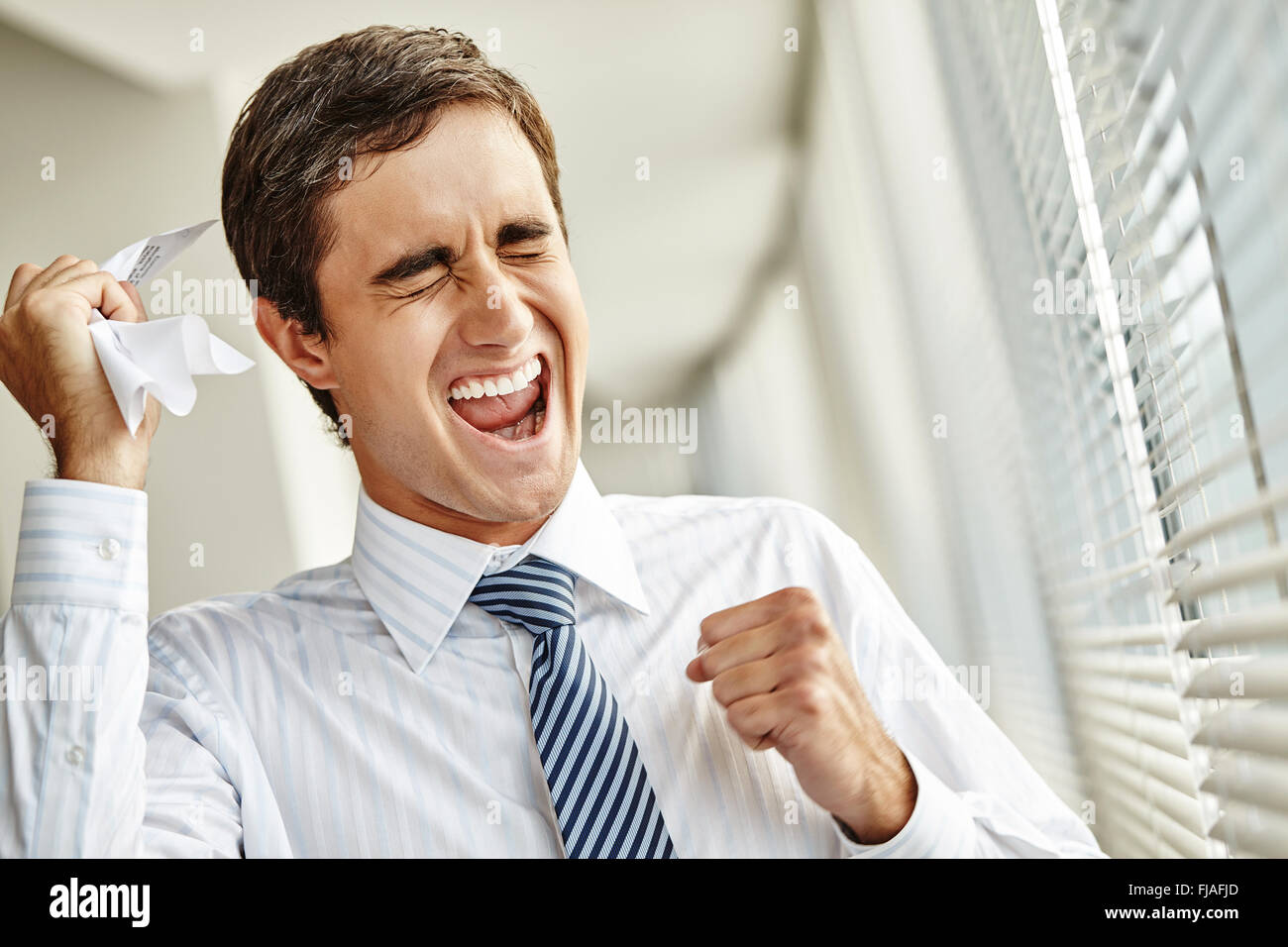 Young businessman screaming with paper in his hand Stock Photo - Alamy