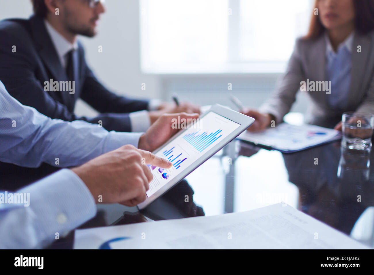 Human hand pointing at touchscreen in working environment at meeting ...