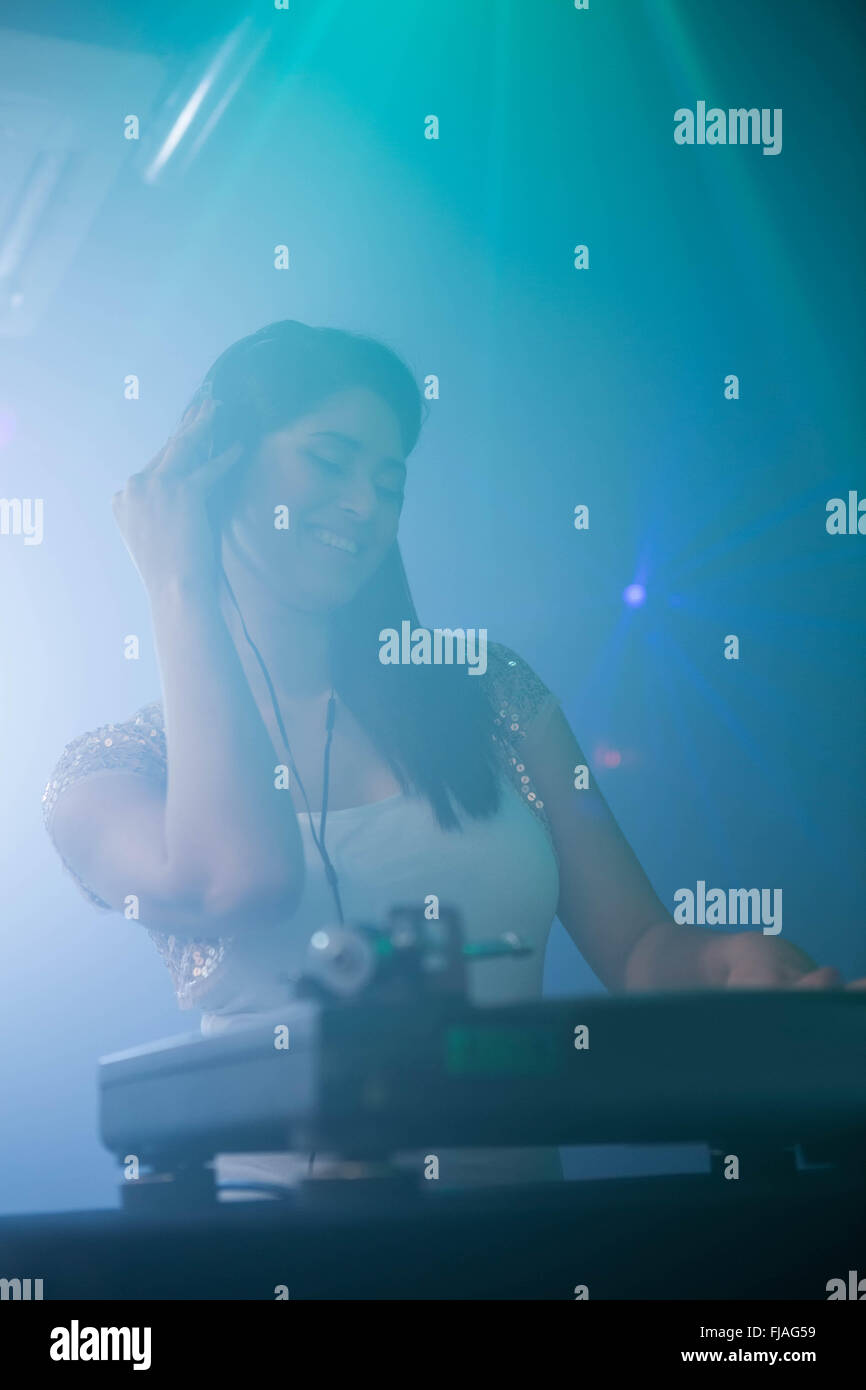 Pretty female DJ playing music Stock Photo - Alamy