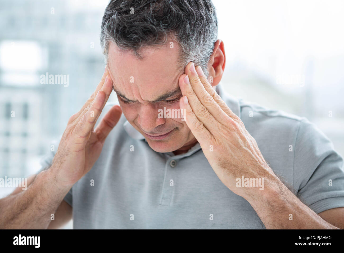 Tensed man touching his temples Stock Photo - Alamy