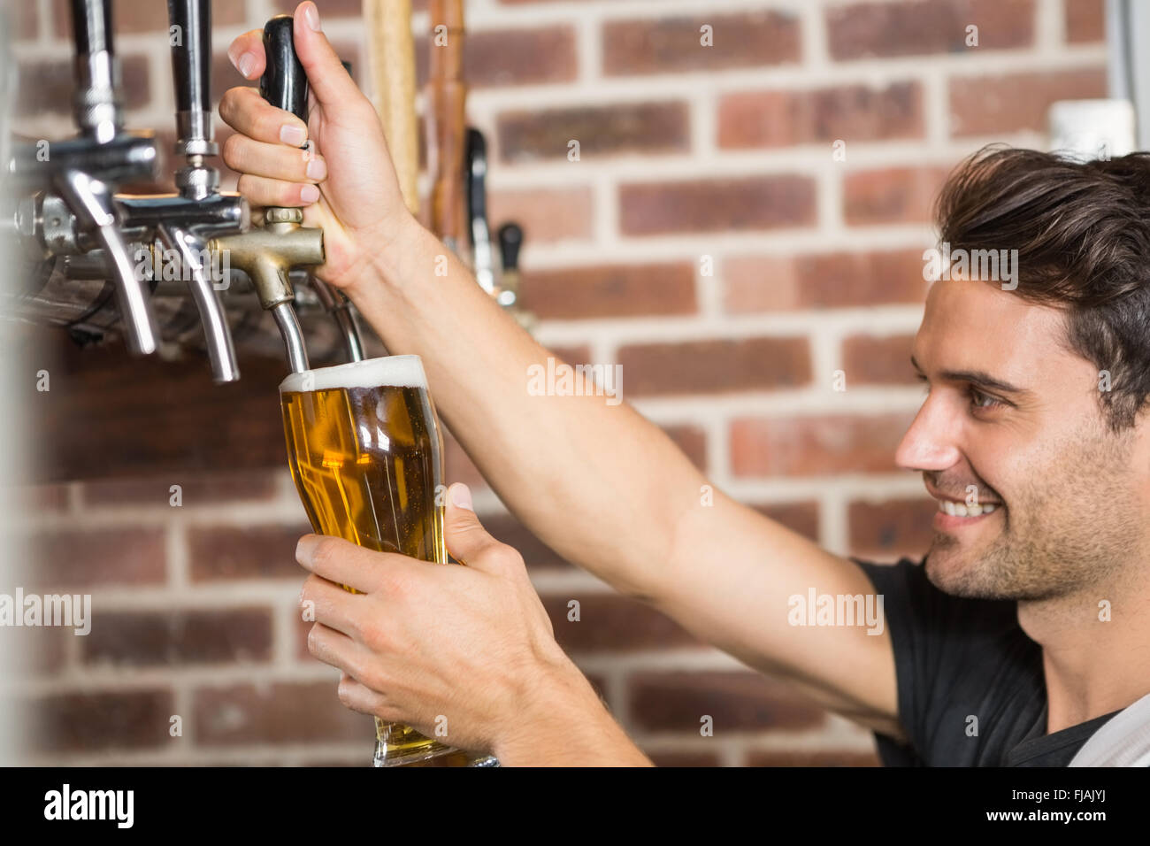 Handsome barman pouring a pint of beer Stock Photo - Alamy