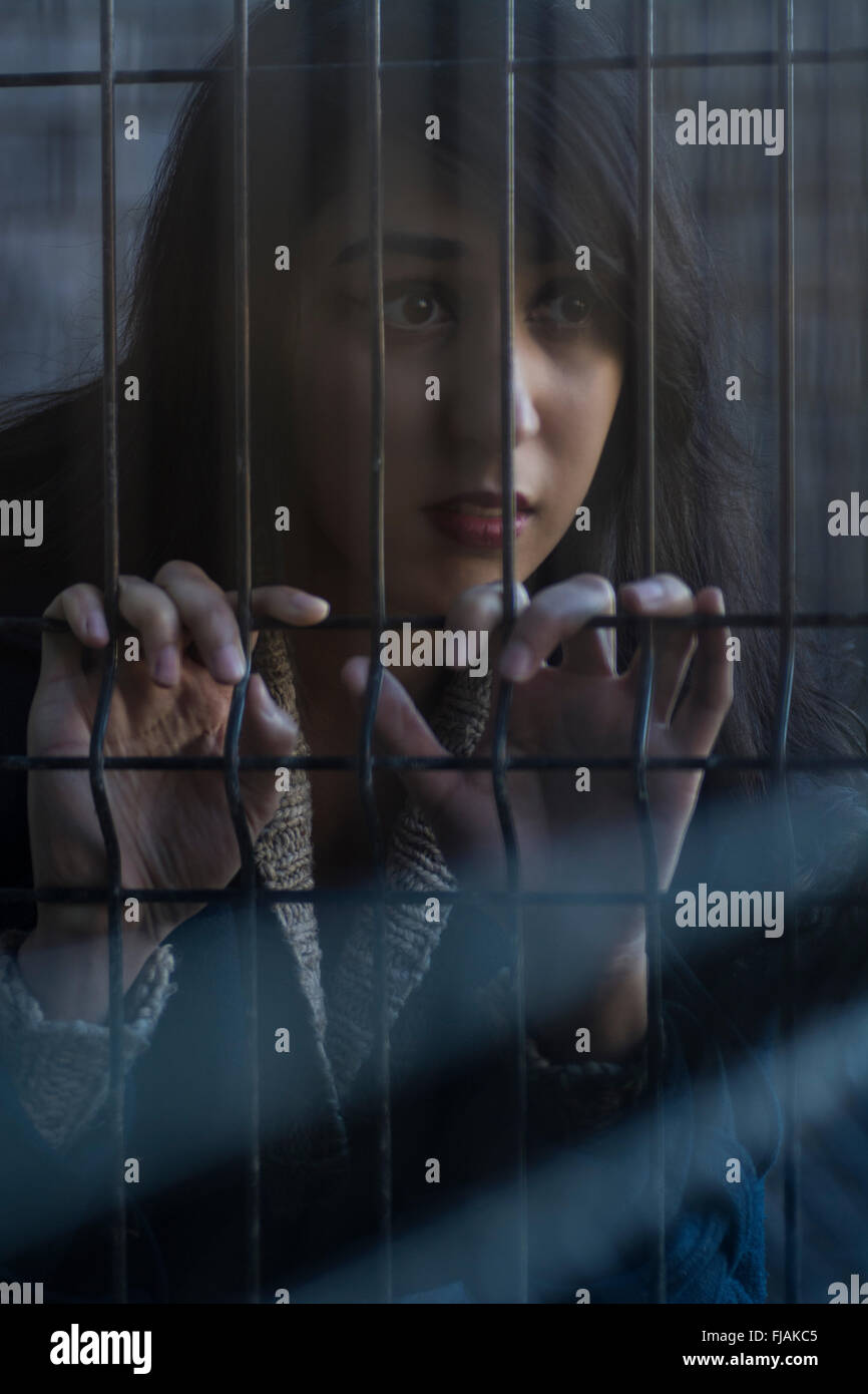 Sad woman behind bars Stock Photo - Alamy