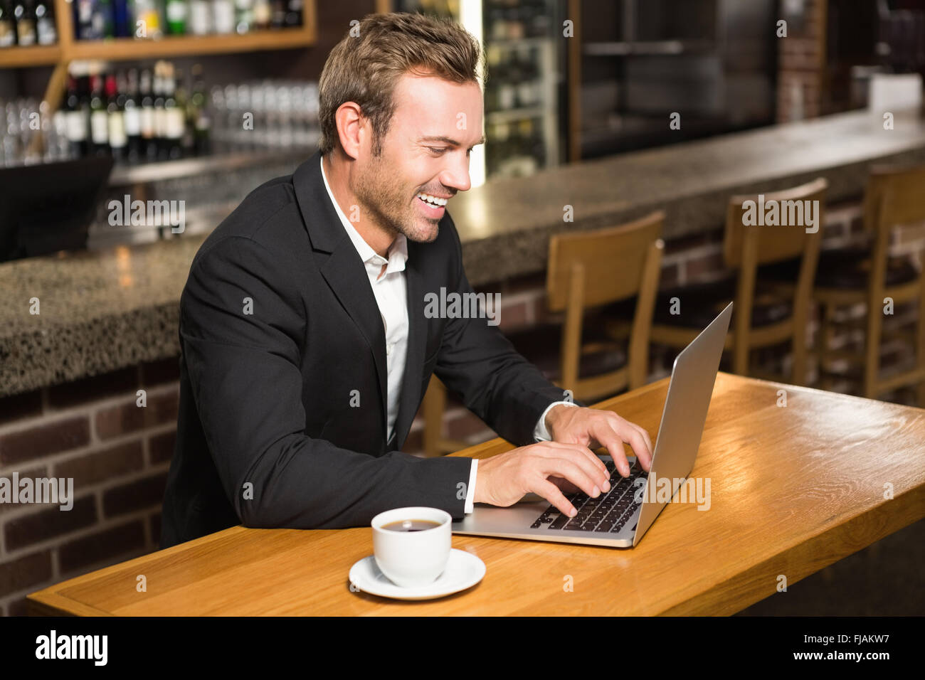 Handsome man using laptop and having a coffee Stock Photo - Alamy