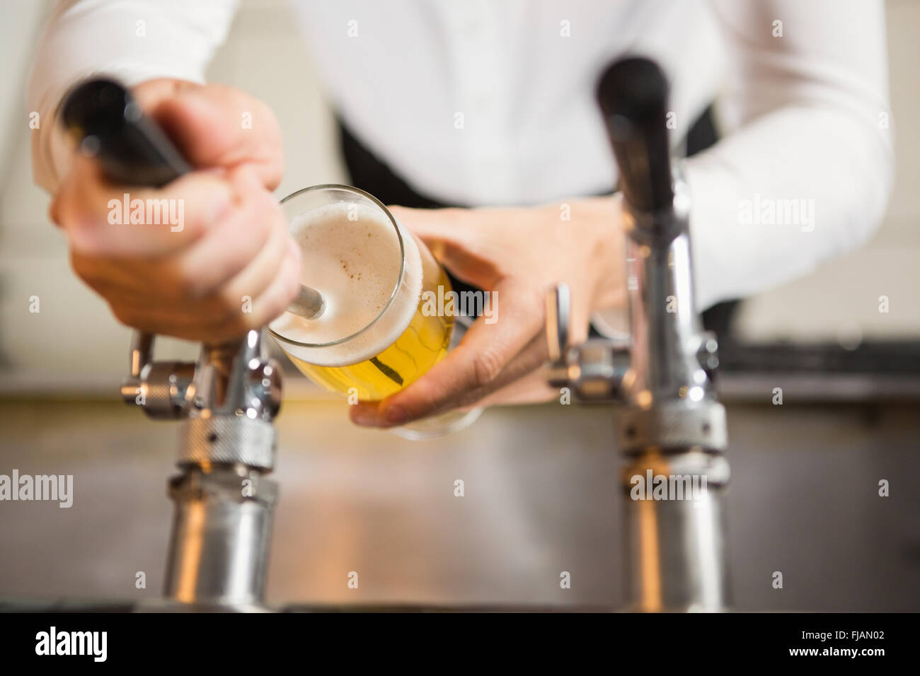 Masculine hands pouring a pint Stock Photo - Alamy