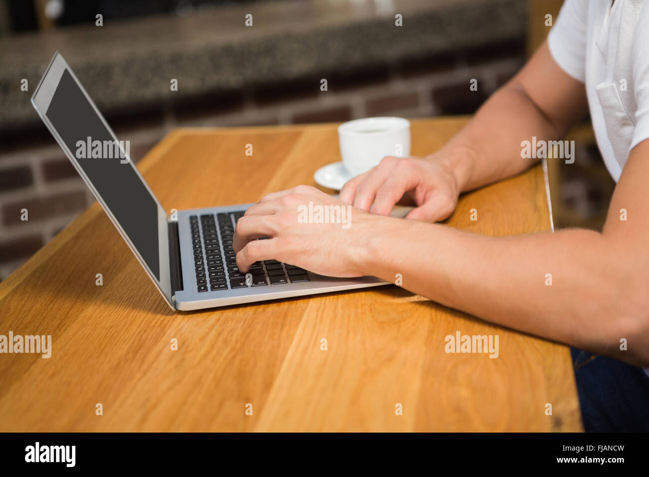 Handsome man using laptop and having coffee Stock Photo - Alamy