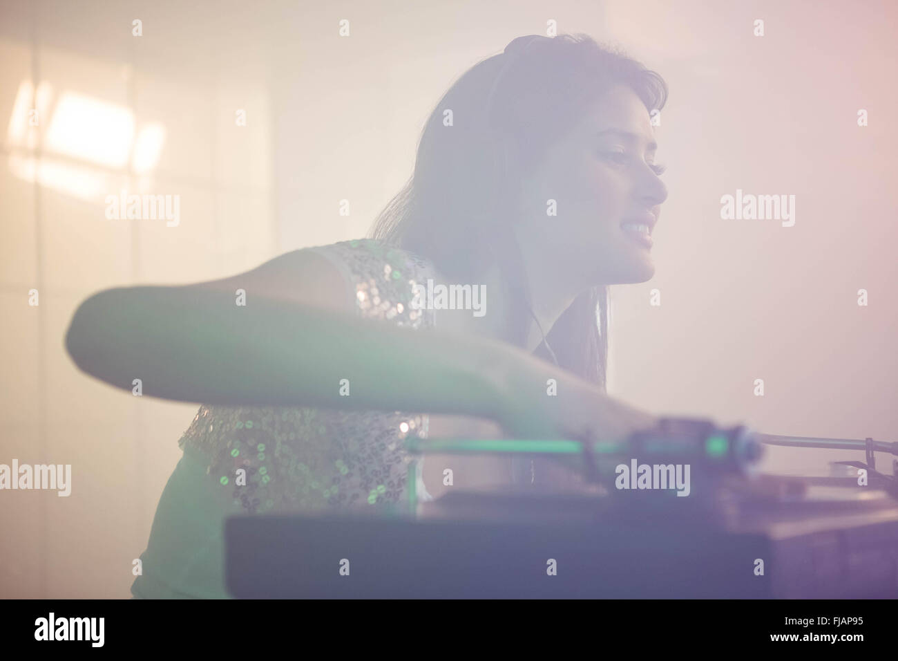 Pretty female DJ playing music Stock Photo - Alamy