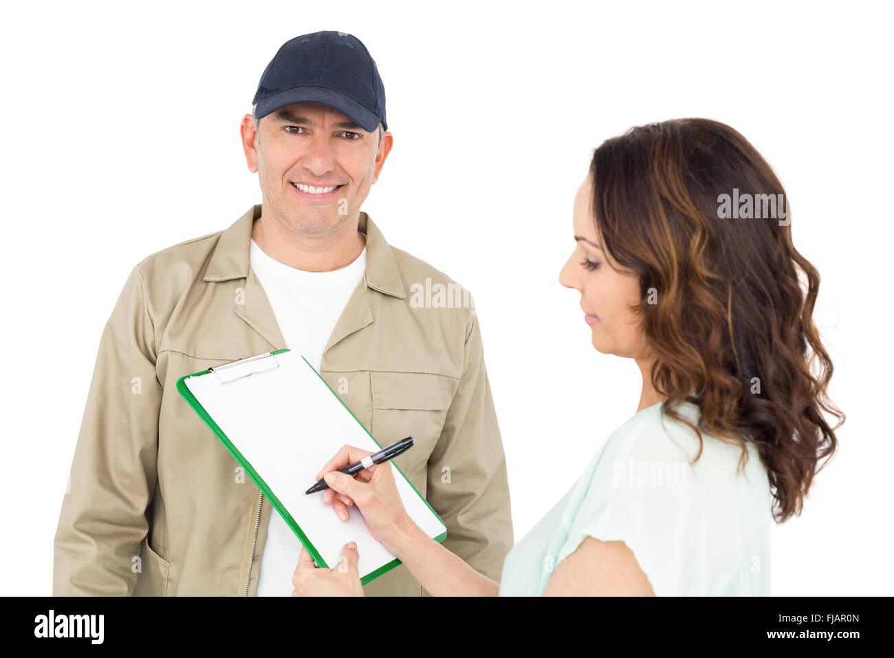 Female customer signing on paper with delivery man Stock Photo - Alamy