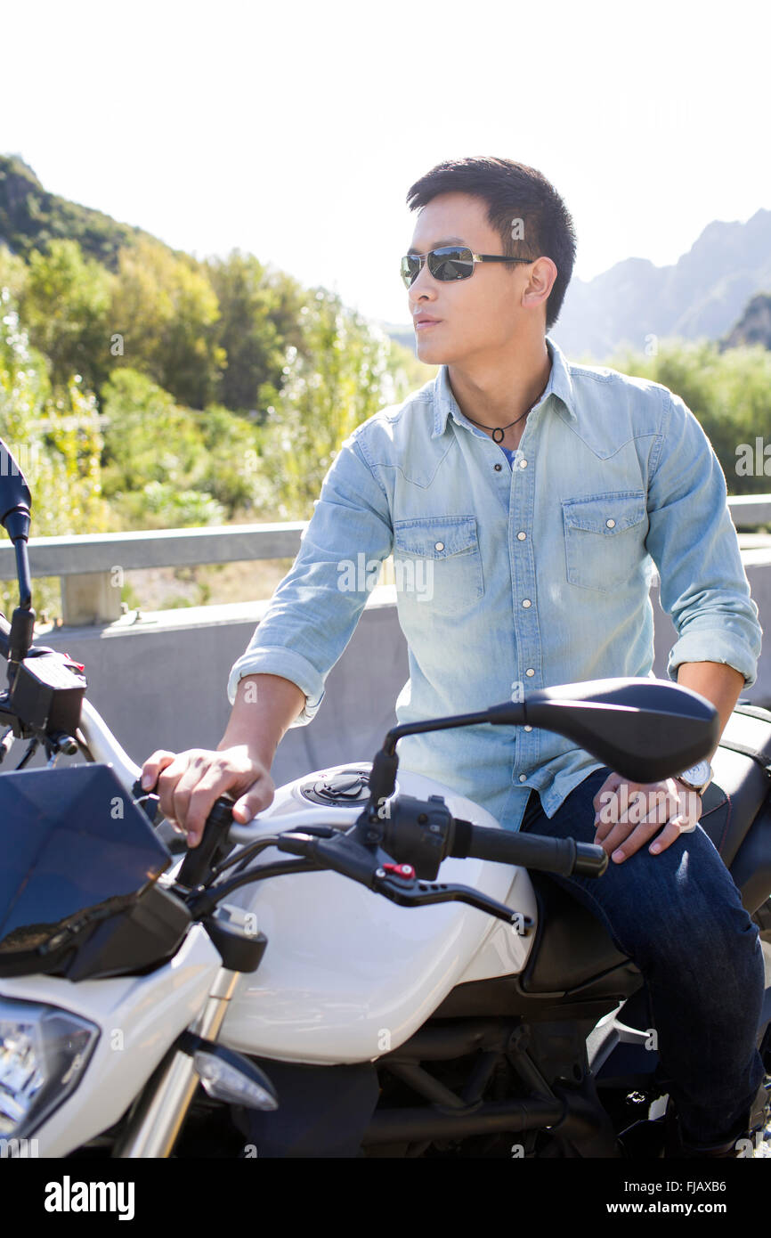 Young Chinese man riding motorcycle Stock Photo - Alamy