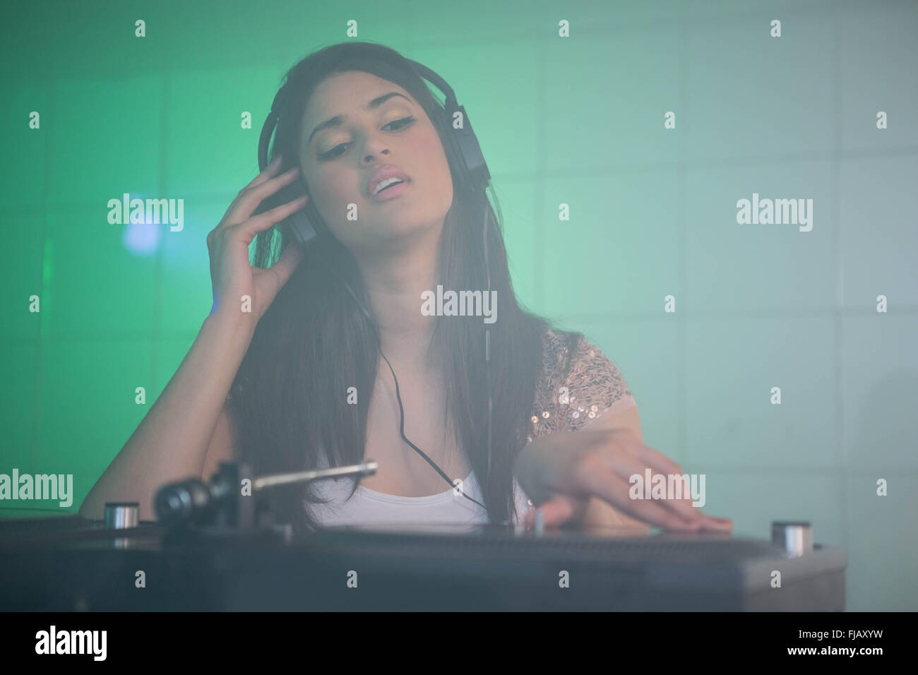 Pretty female DJ playing music Stock Photo - Alamy