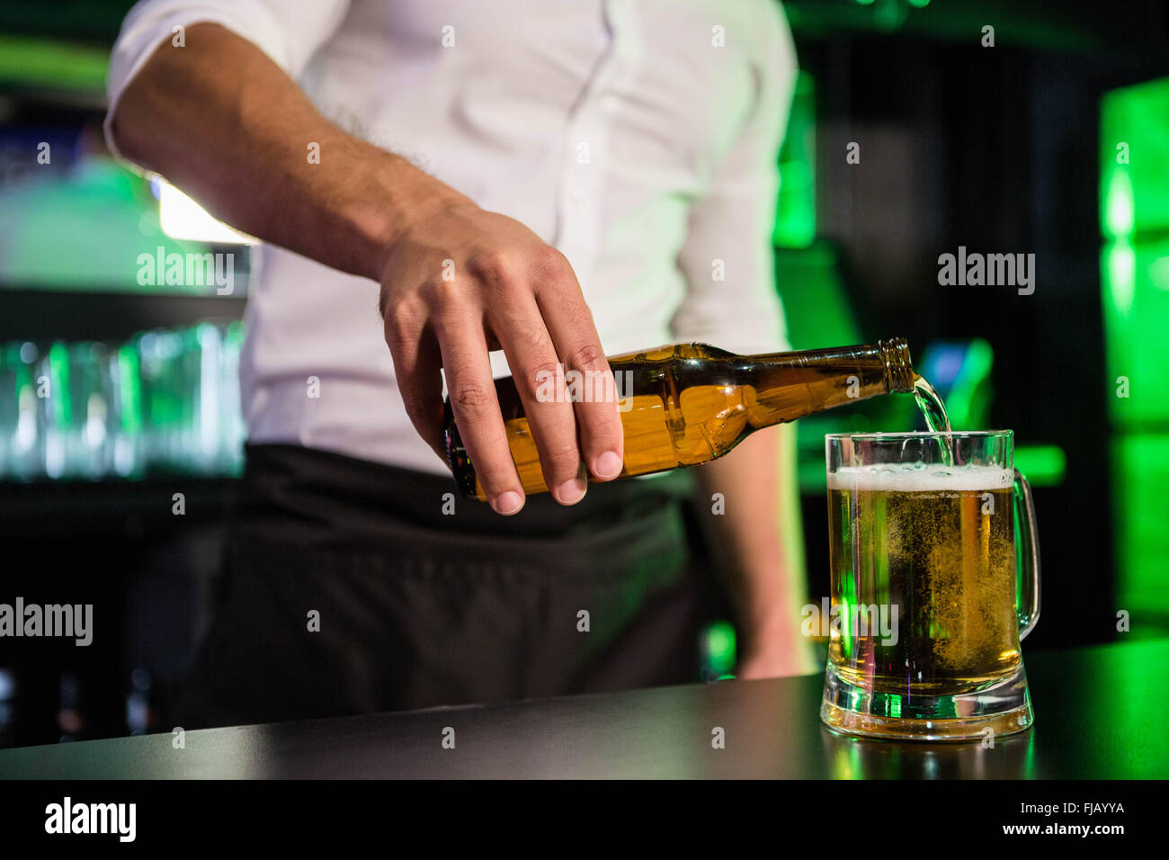 Mid section of bartender pouring beer in a glass Stock Photo - Alamy