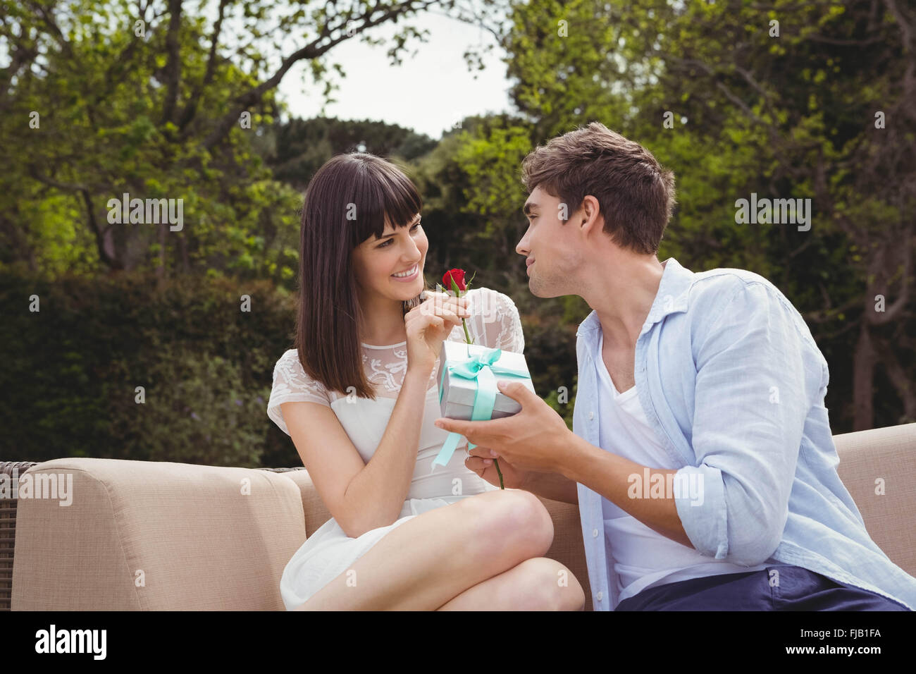 Man giving a surprise gift to woman Stock Photo - Alamy