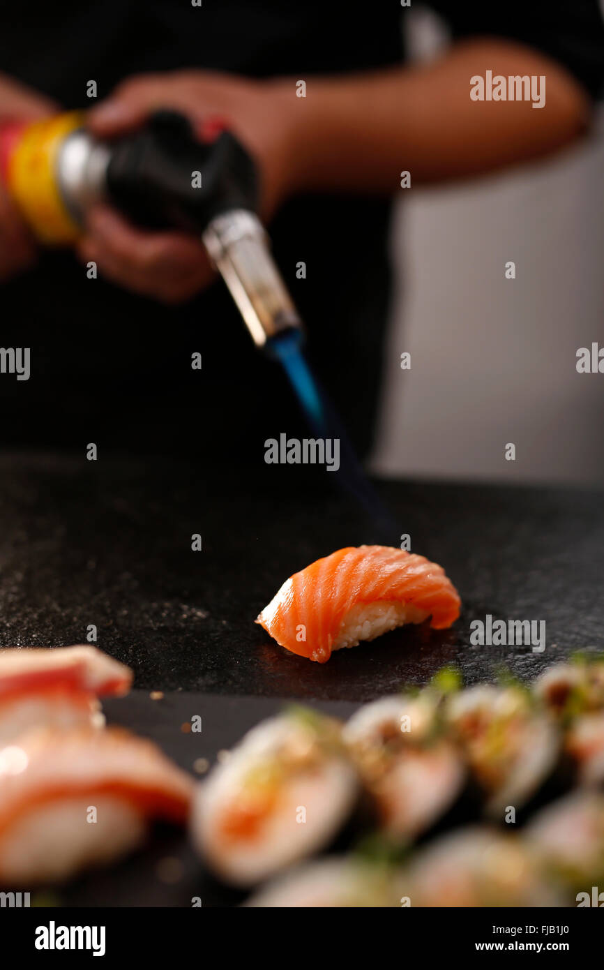 Sushi with raw salmon burning flame. Nigiri sushi with salmon burning ...