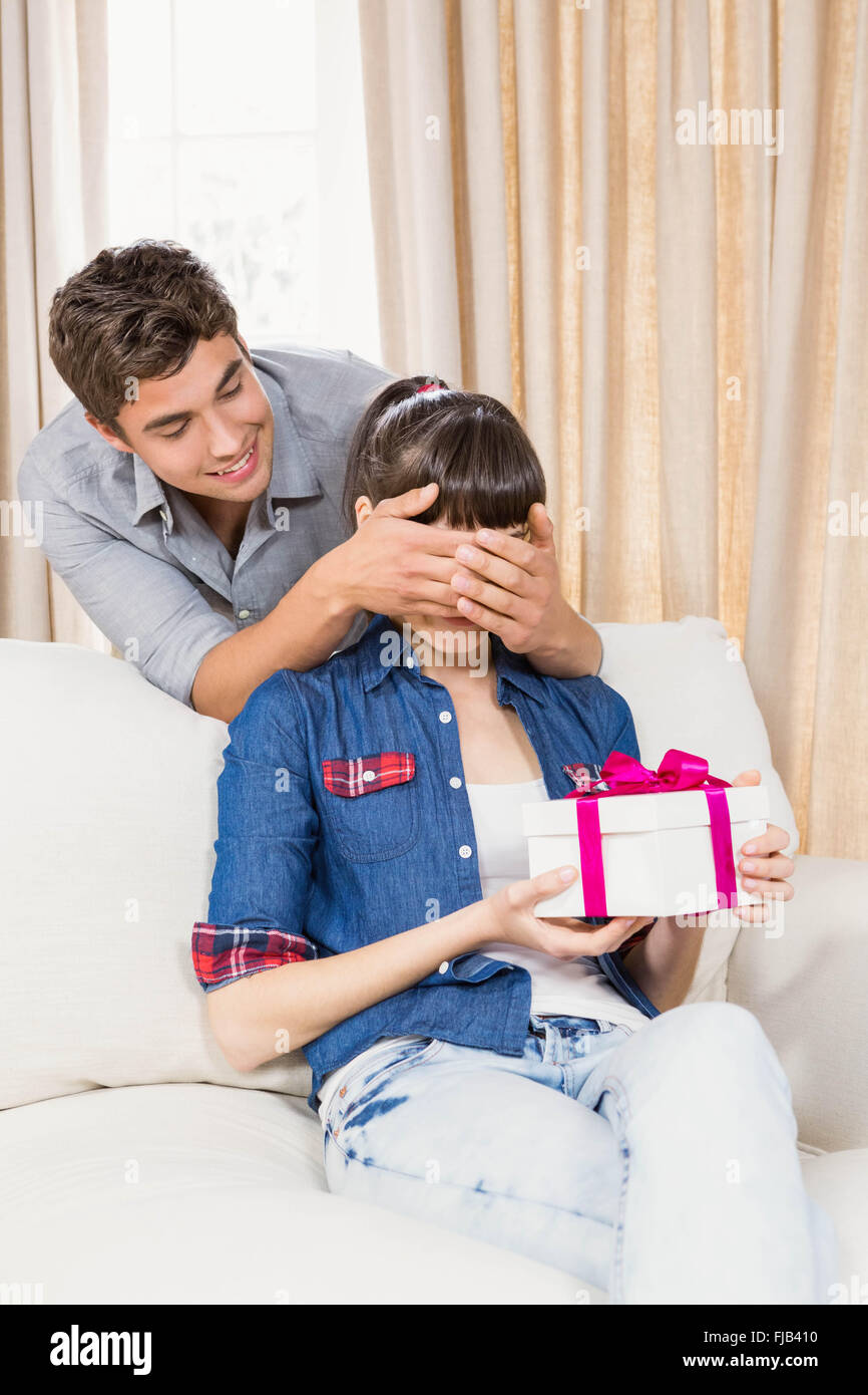 Young woman receiving a surprise gift Stock Photo - Alamy