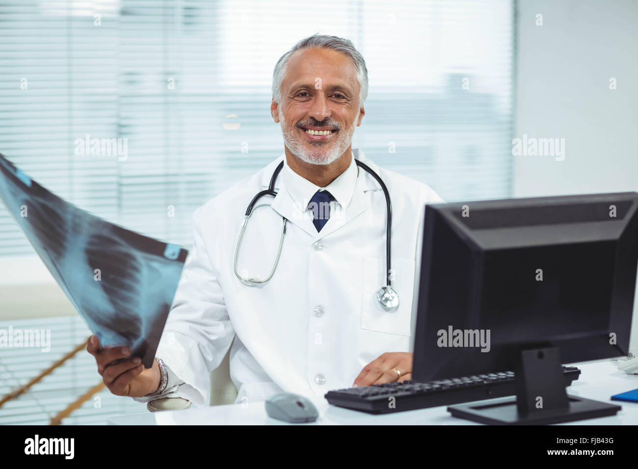 Happy doctor holding x-ray in clinic Stock Photo - Alamy