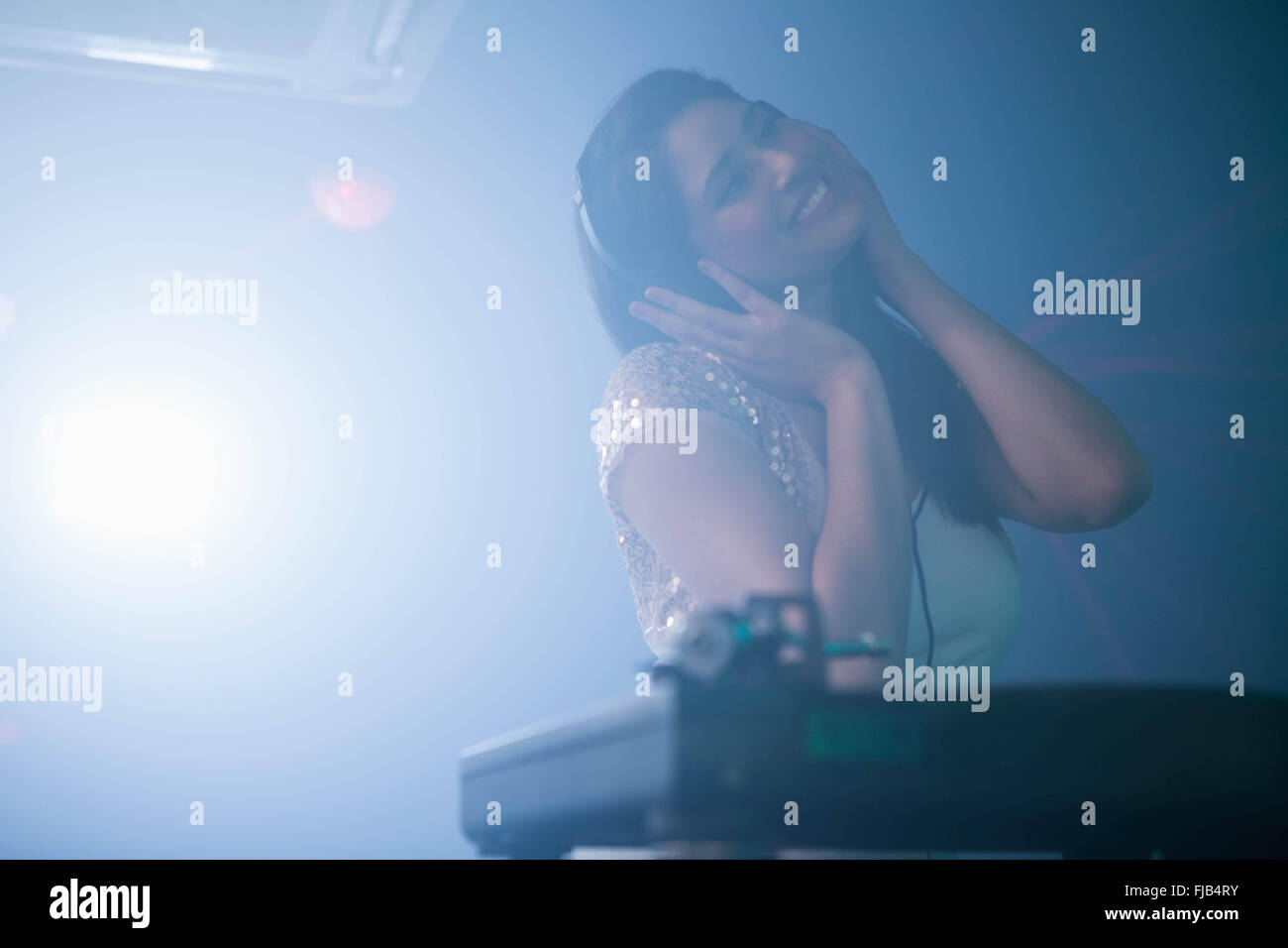 Pretty female DJ playing music Stock Photo - Alamy