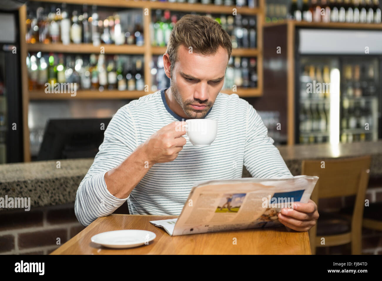 Handsome man reading newspaper and having a coffee Stock Photo - Alamy