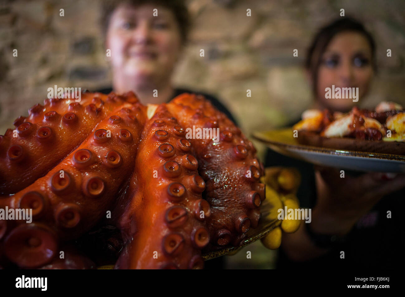 Waitresses showing at left Octopus and at right ´Pulpo a feira´ octopus ...