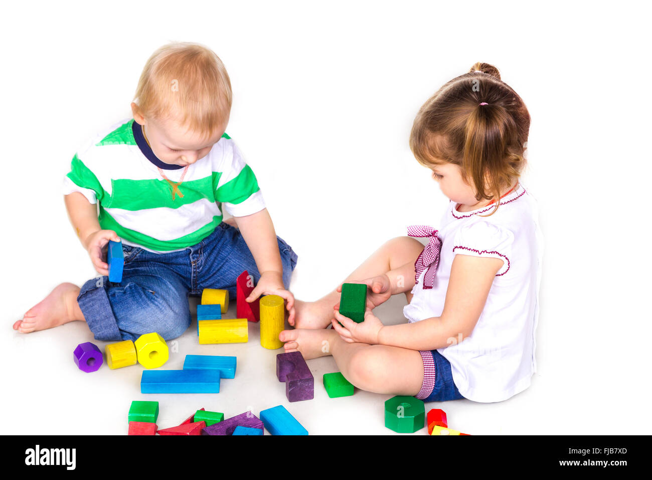 Happy kids playing with building blocks isolated on white. Team work ...
