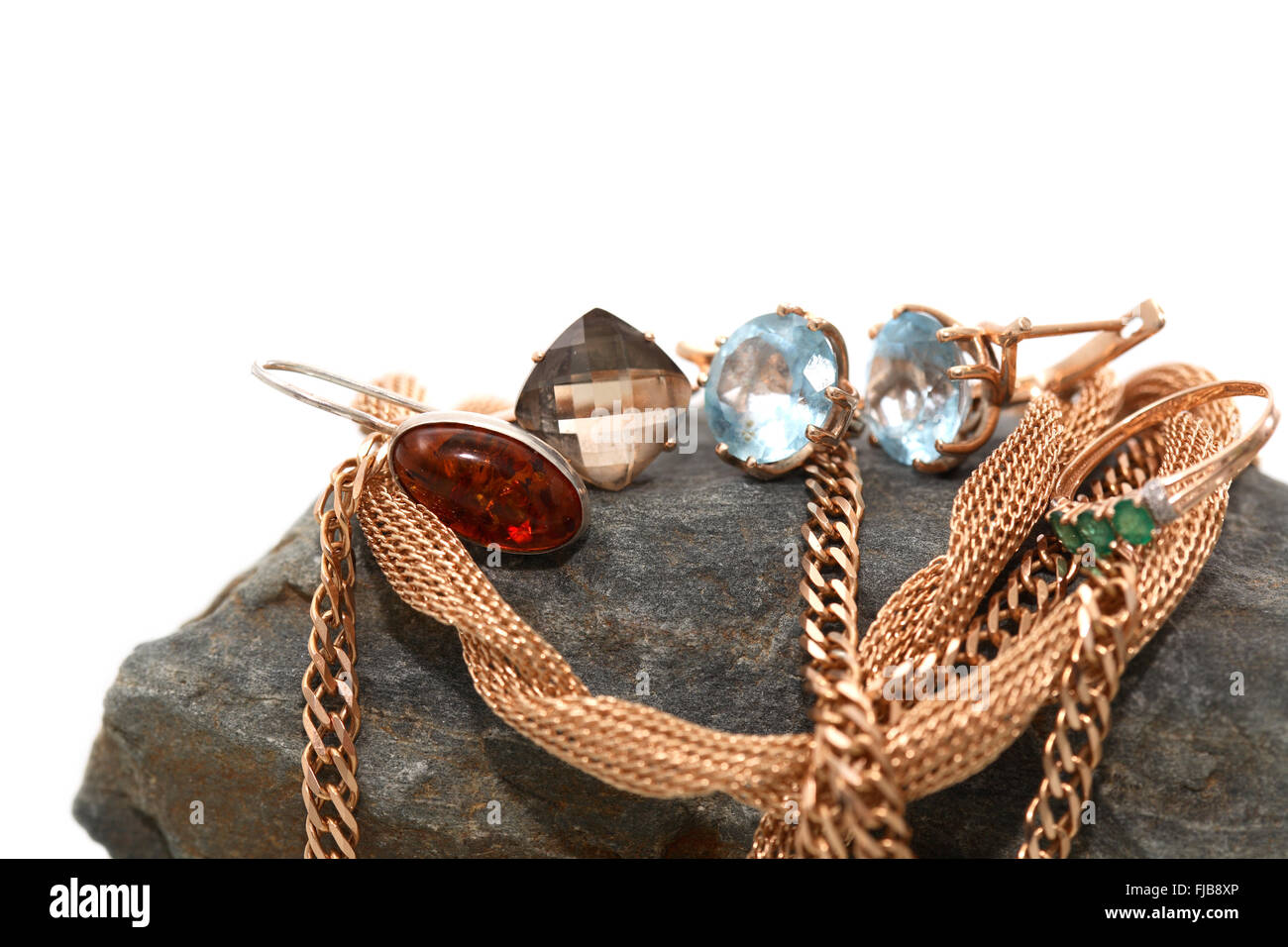 Set of various jewelry adornments on stone against white background ...