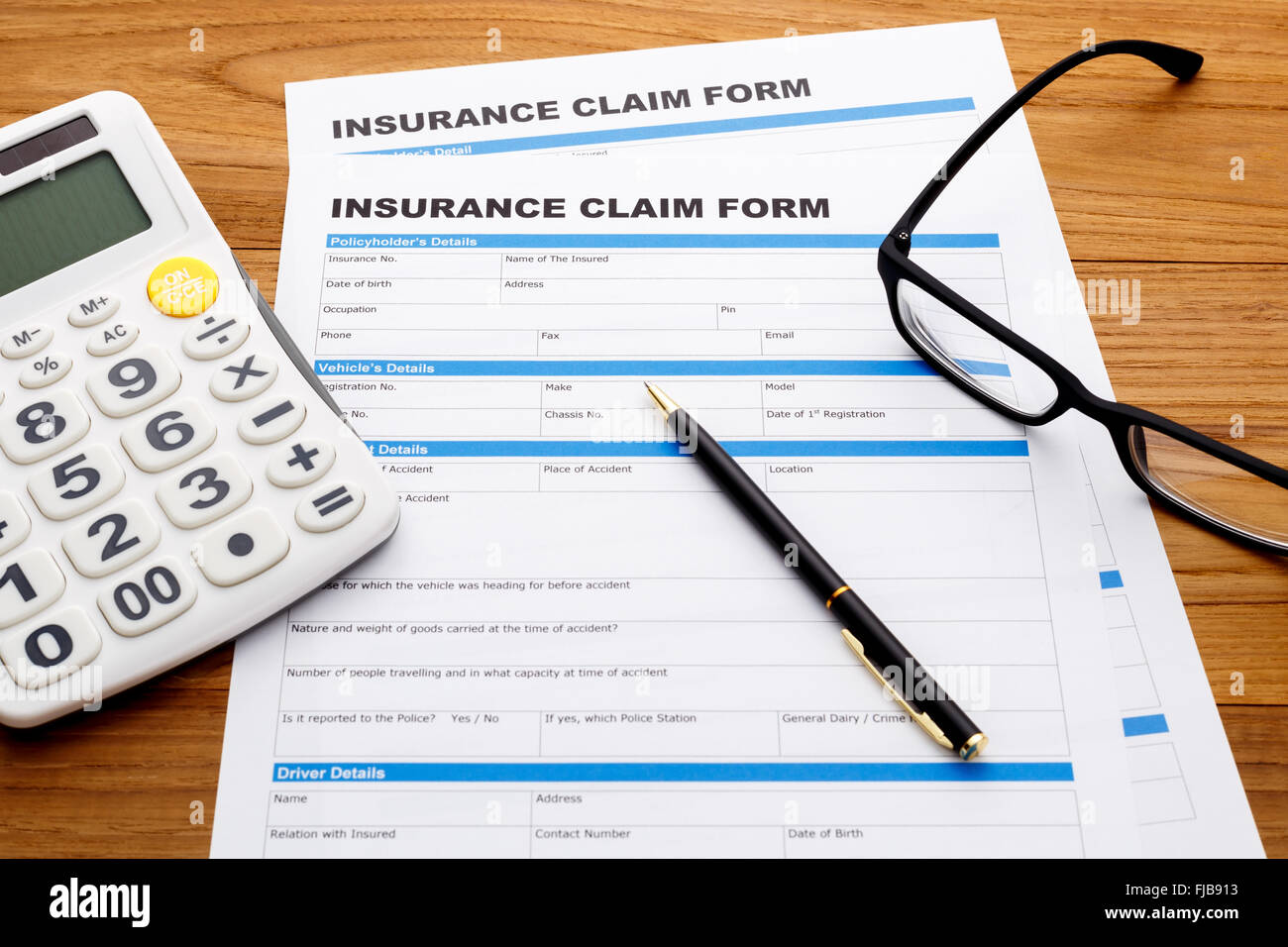 Insurance claim form with pen and calculator on wood desk Stock Photo ...