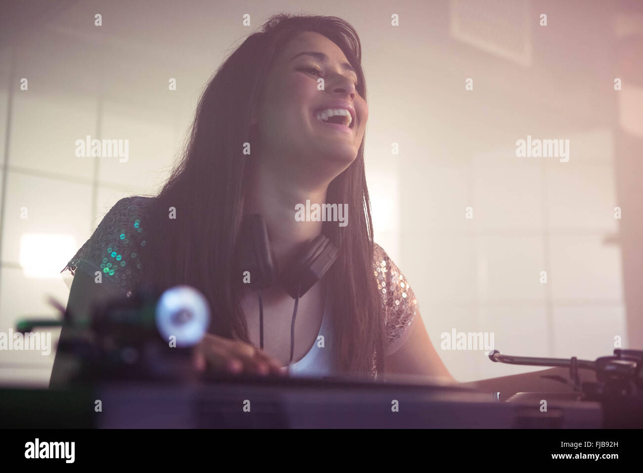 Pretty female DJ playing music Stock Photo - Alamy