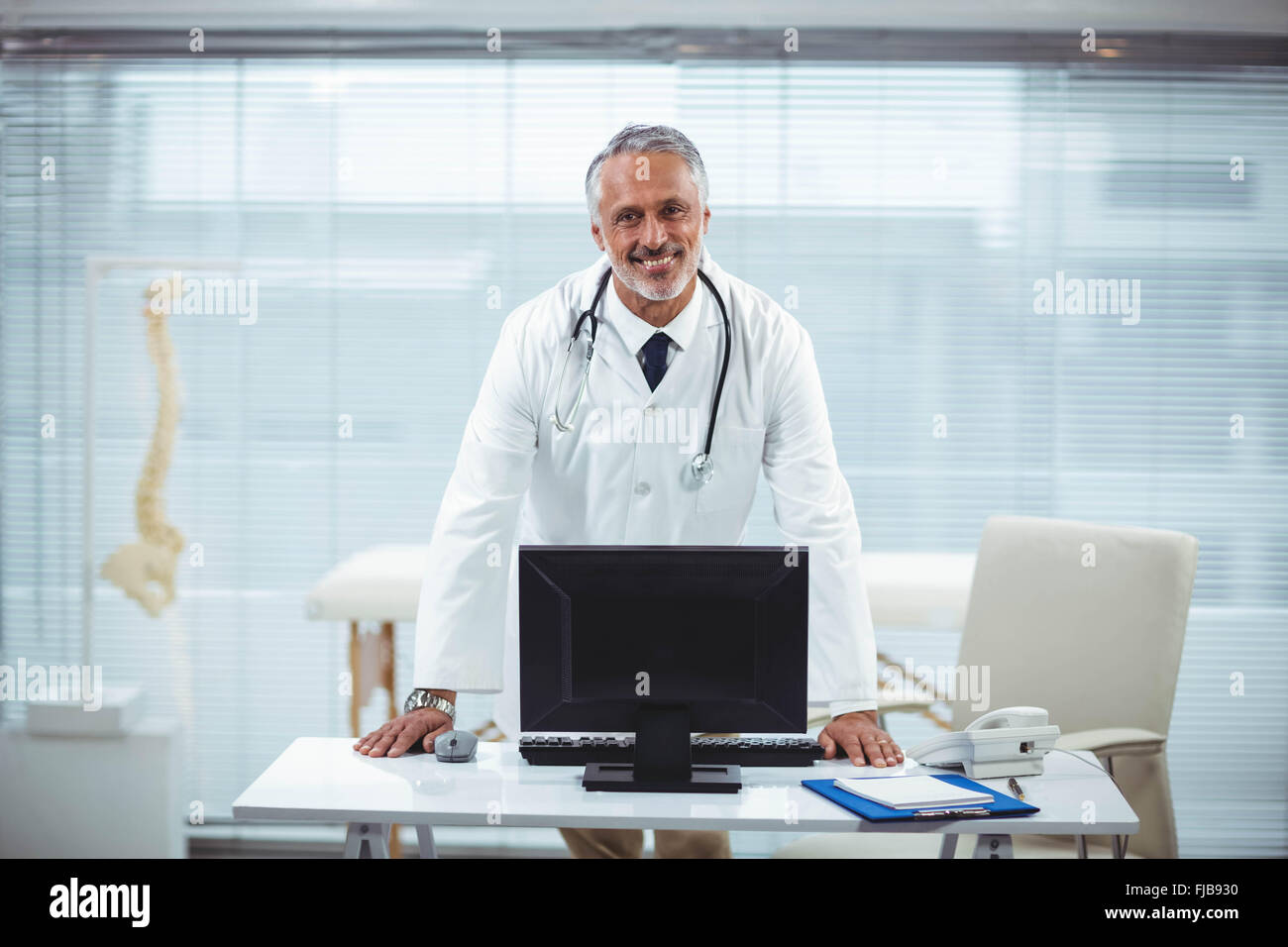 Doctor at his desk in clinic Stock Photo - Alamy