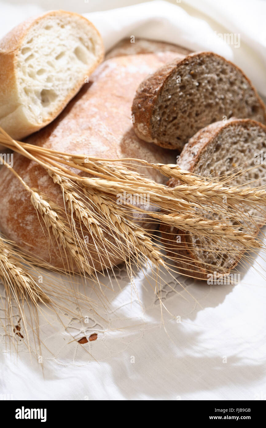 Farm still life. Freshness bread set on white tablecloth near wheat ...