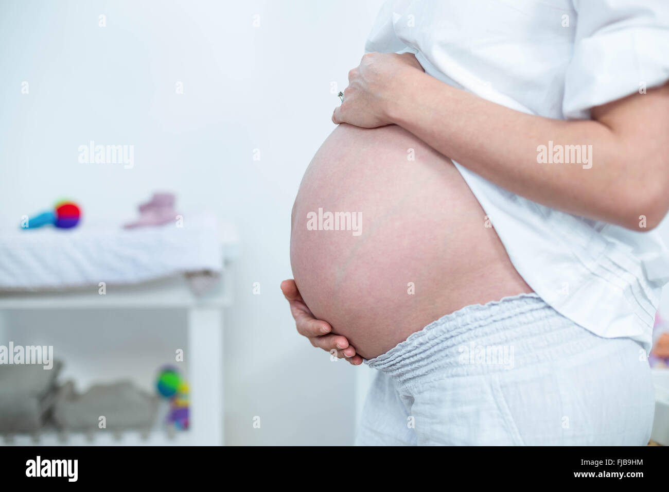 Pregnant woman touching her belly Stock Photo - Alamy