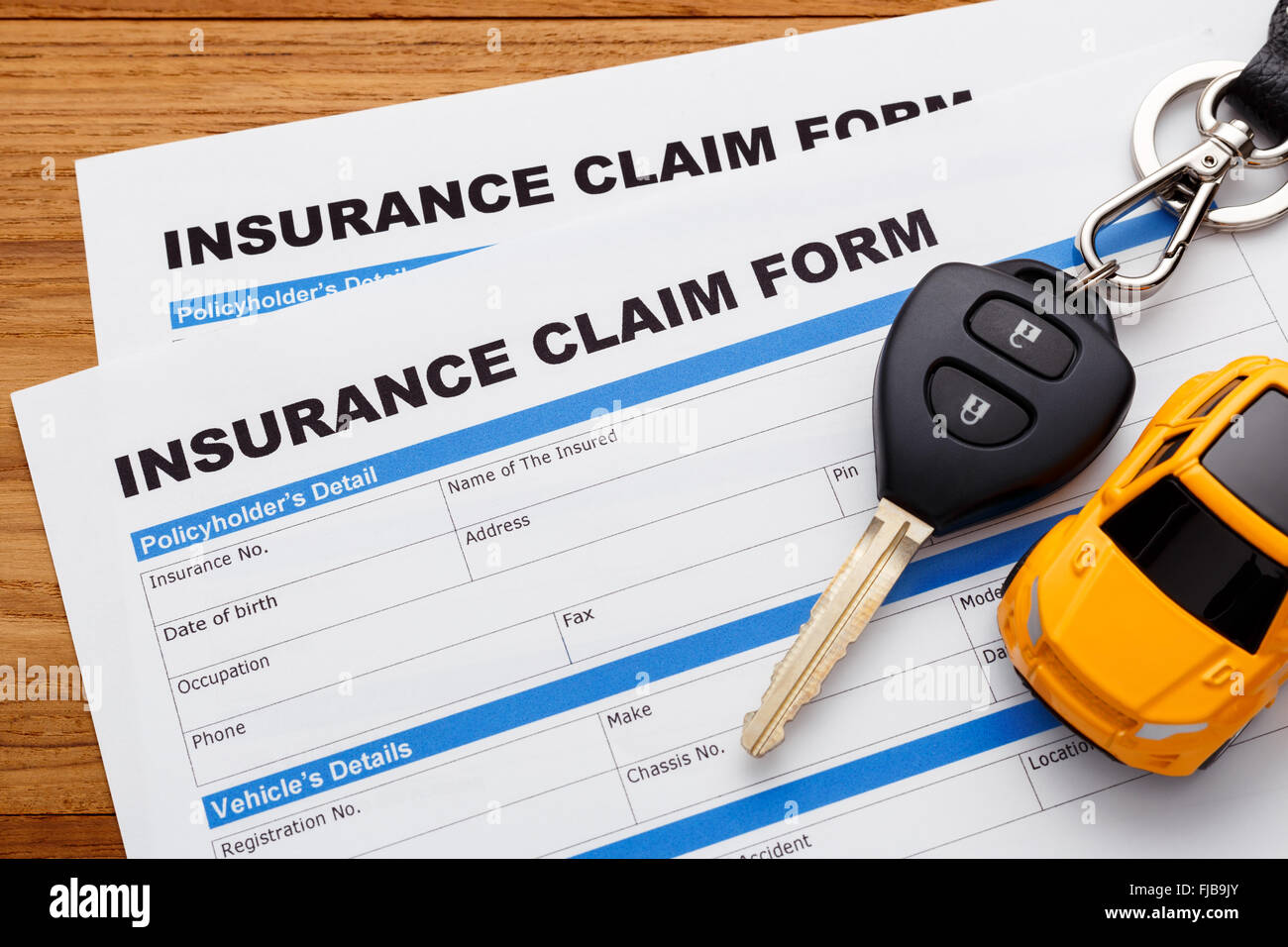 Car insurance claim concept with car key on wood desk Stock Photo - Alamy