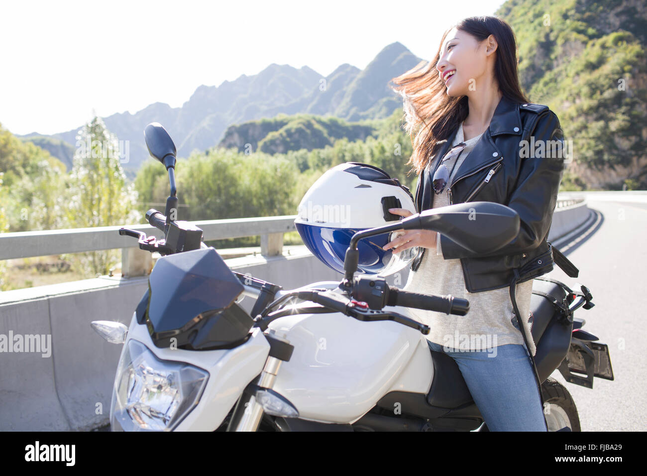 Young Chinese woman riding motorcycle Stock Photo - Alamy