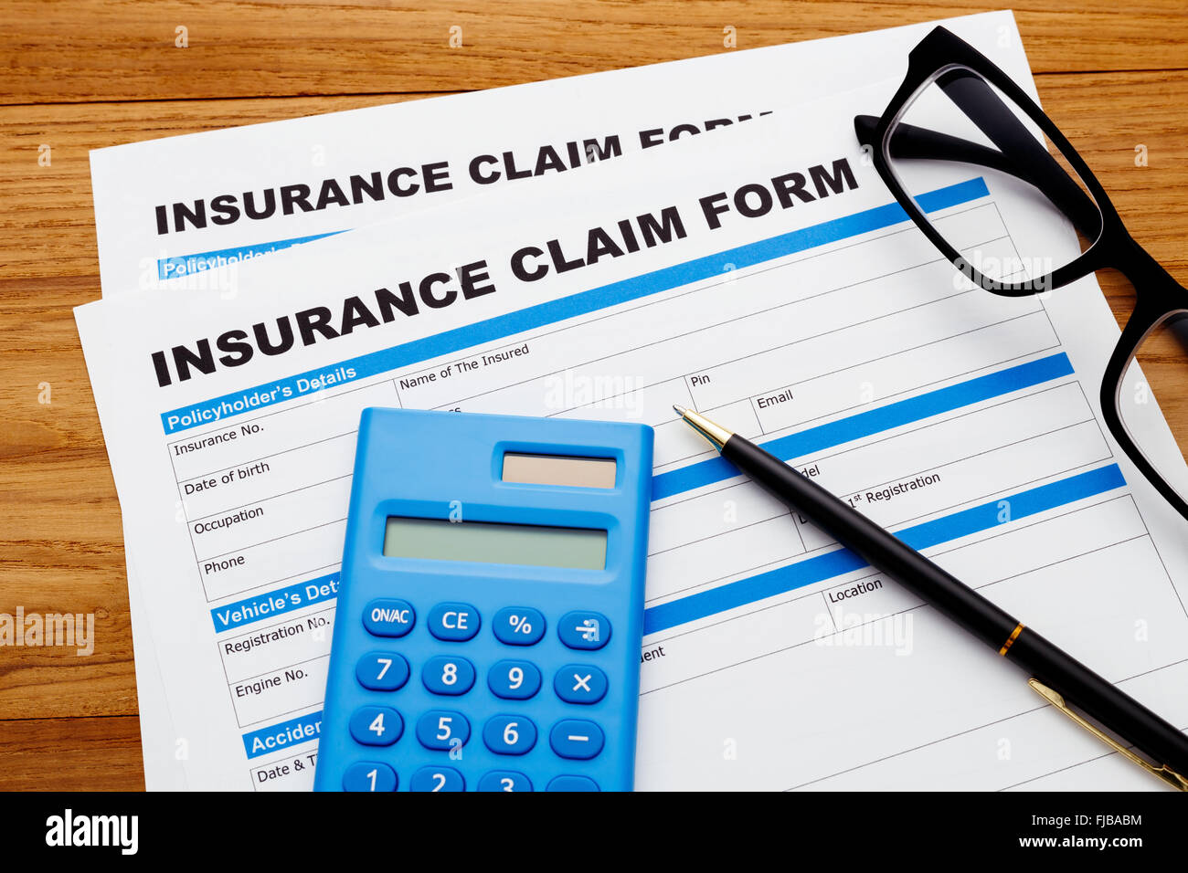 Insurance claim concept with pen and calculator on wood desk Stock ...