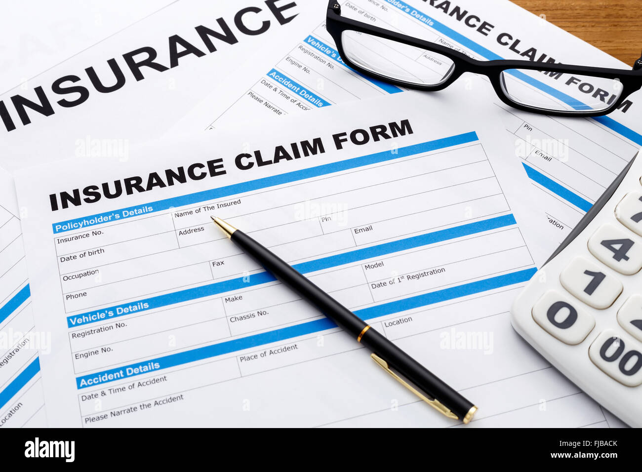 Insurance claim form with pen and calculator on wood desk Stock Photo ...