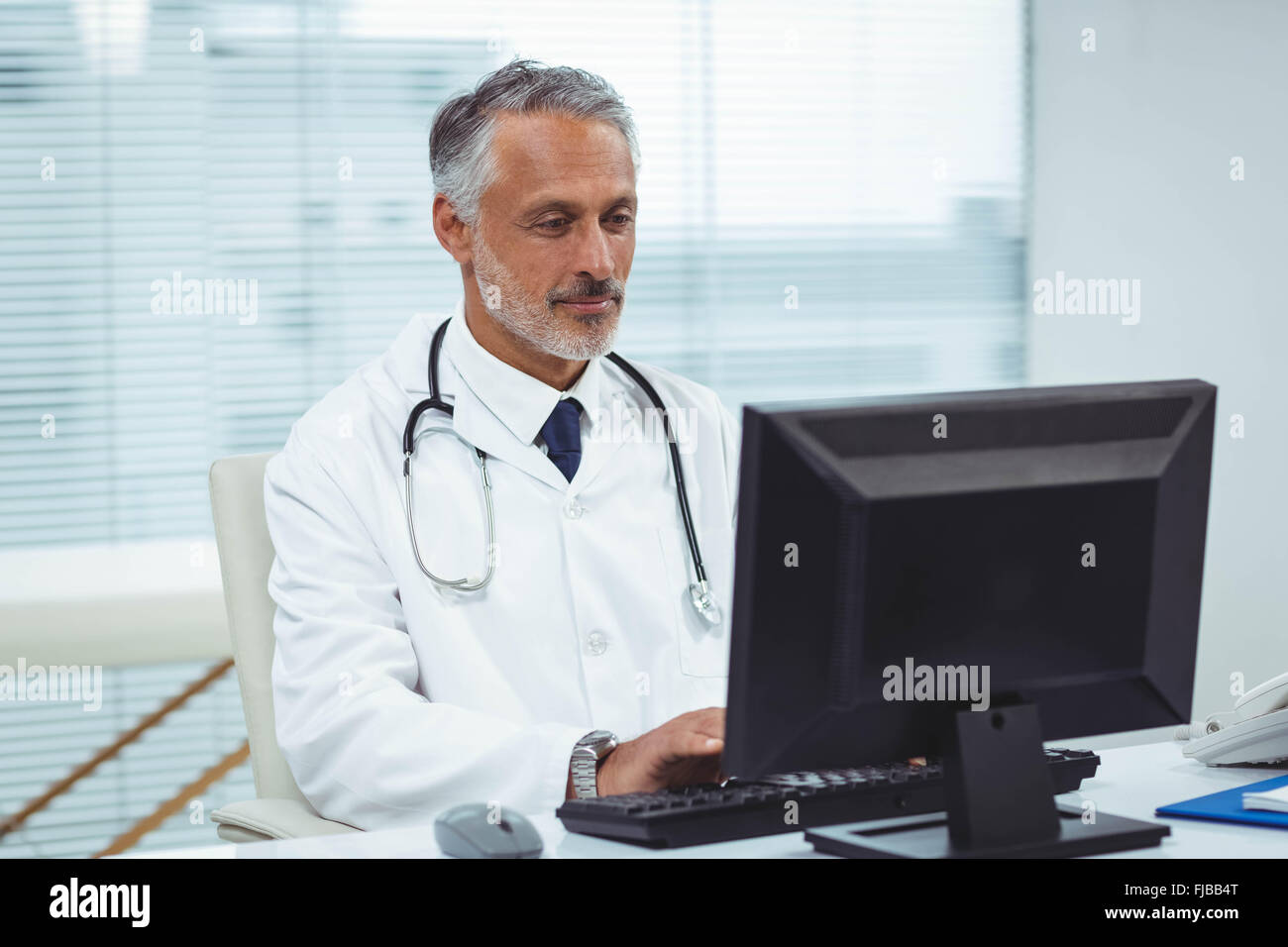Doctor typing on his computer Stock Photo - Alamy