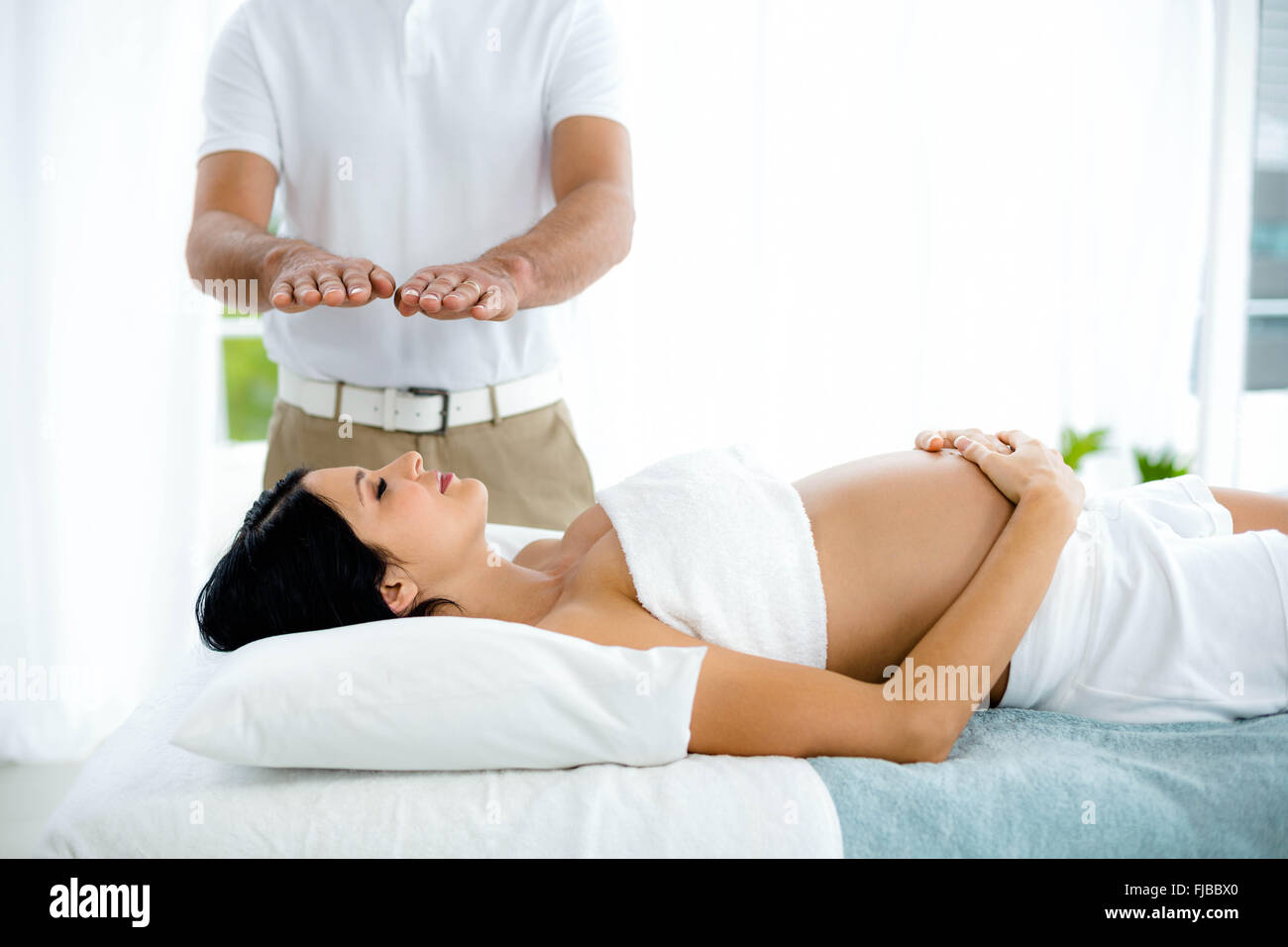 Pregnant woman receiving a spa treatment from masseur Stock Photo - Alamy