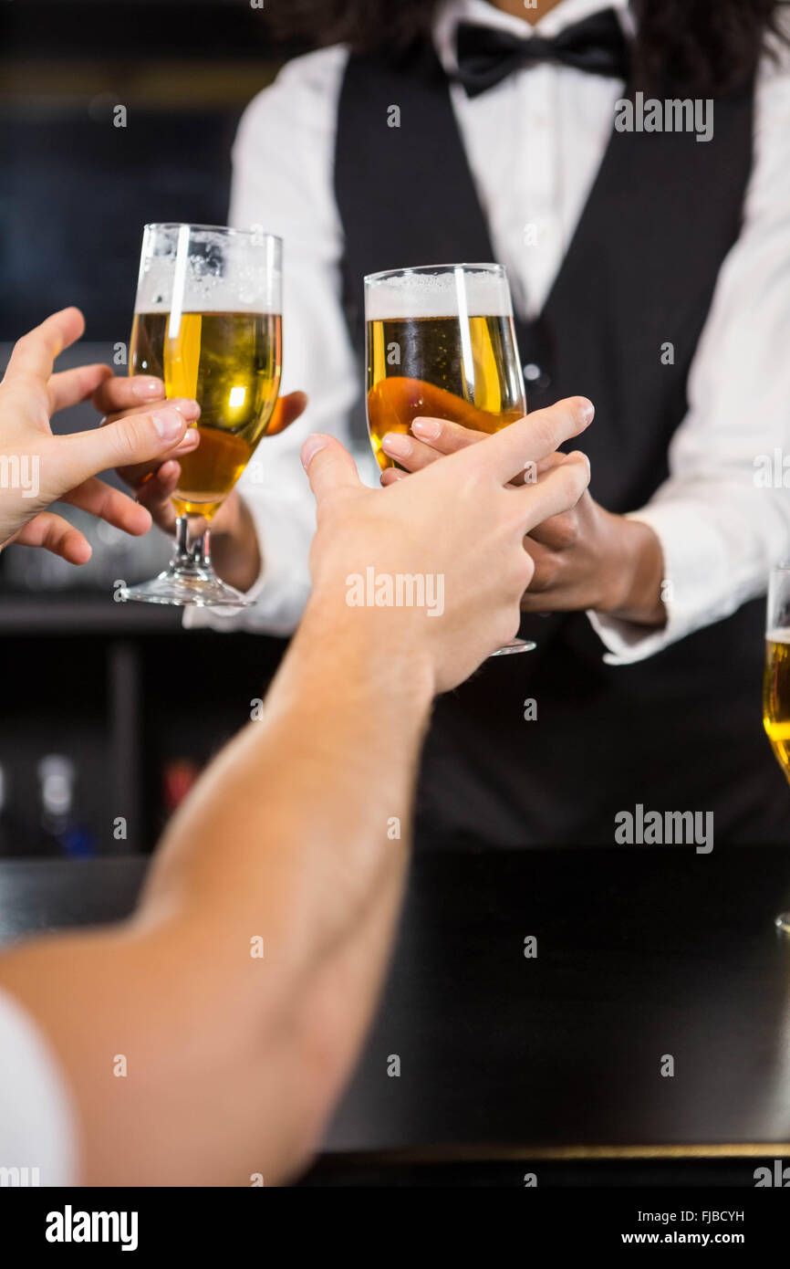 Female bartender serving beer at bar counter Stock Photo - Alamy