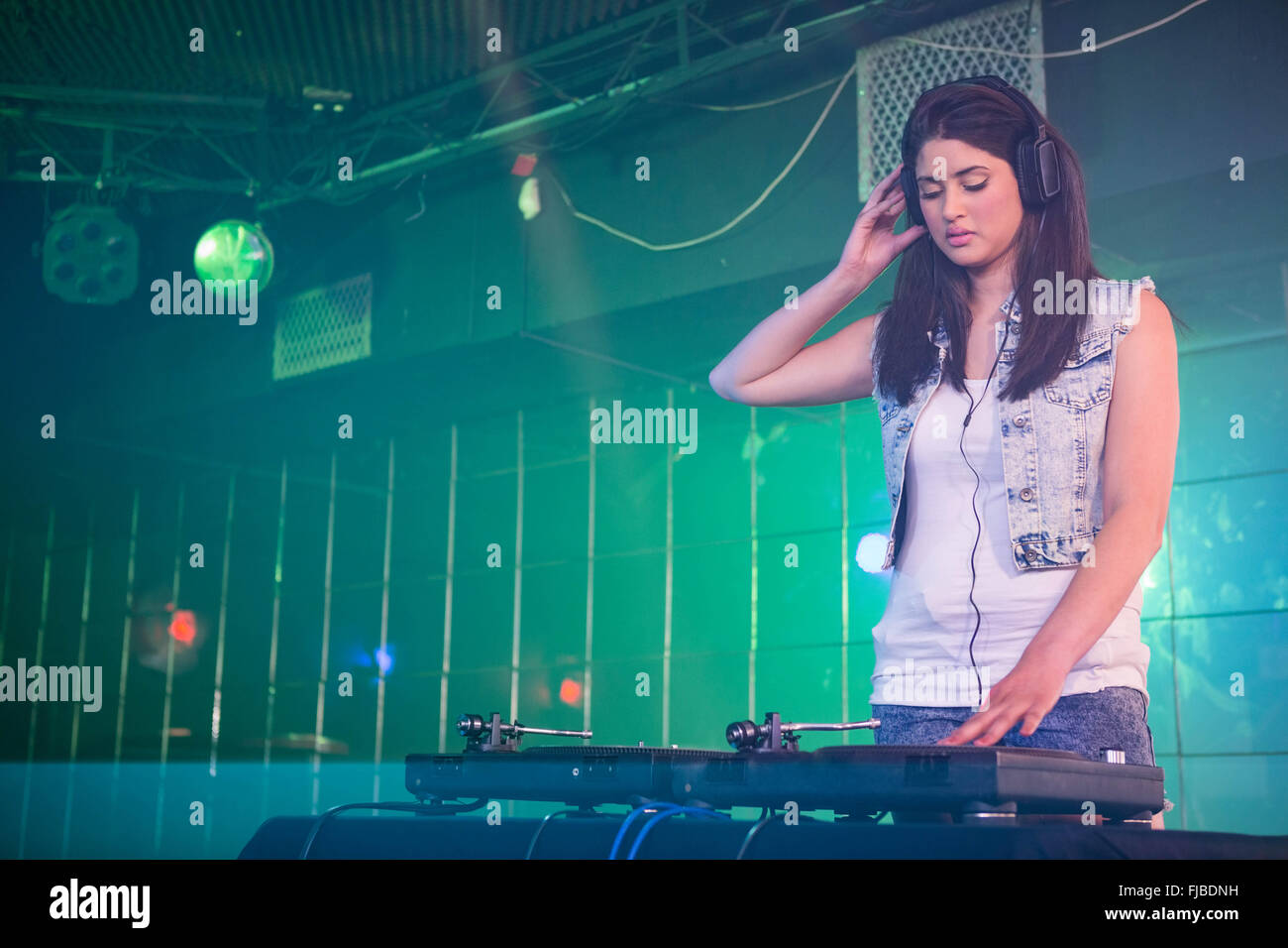 Pretty female DJ playing music Stock Photo - Alamy