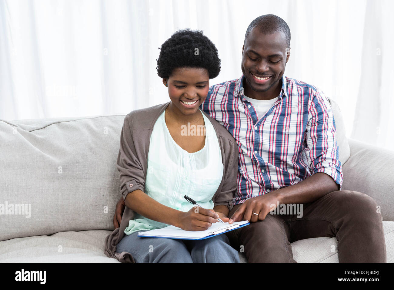 Pregnant couple writing on a notepad Stock Photo - Alamy