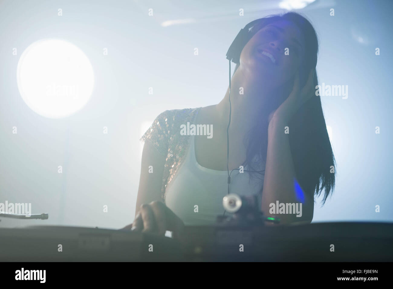 Pretty female DJ playing music Stock Photo - Alamy