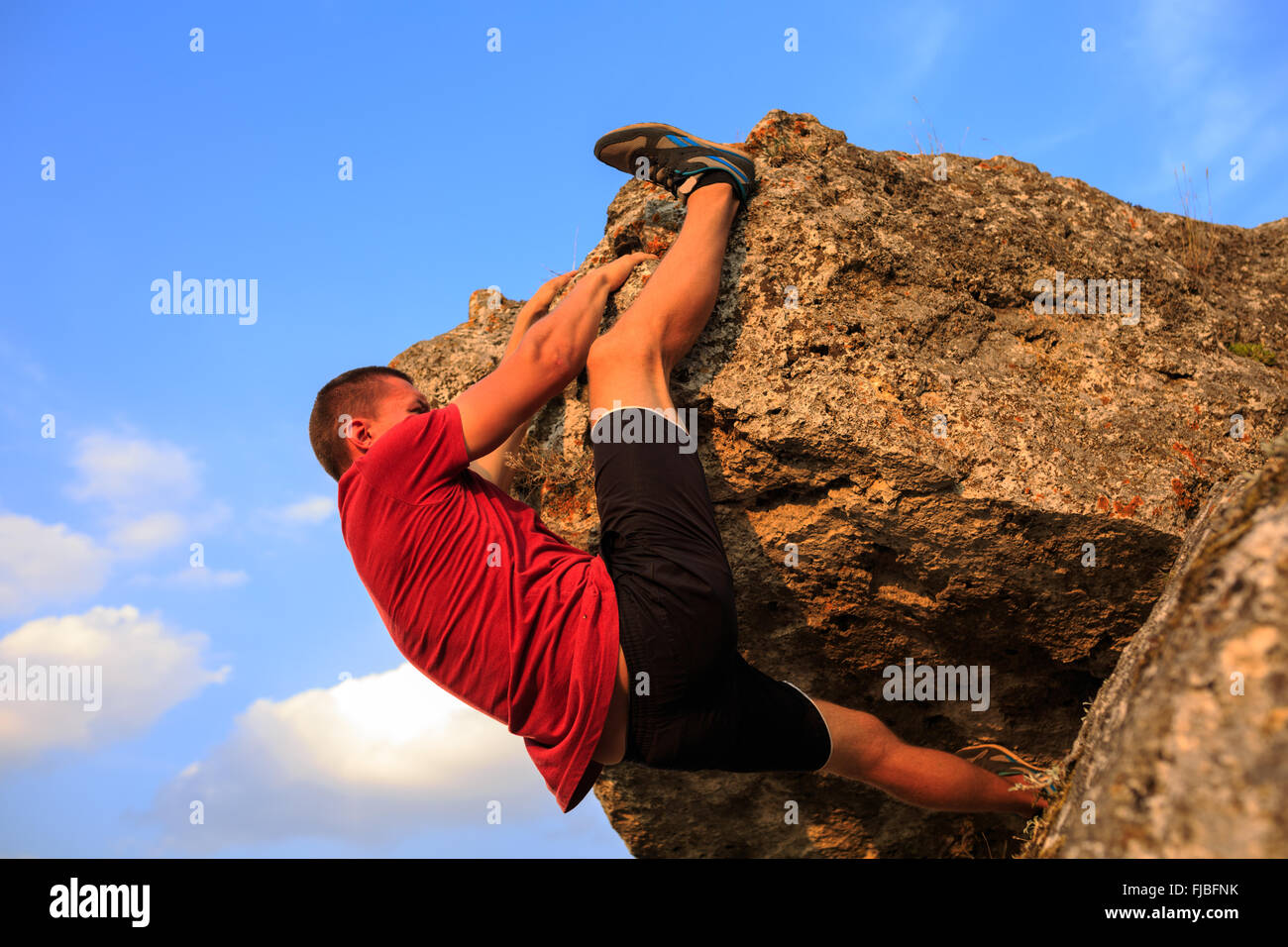 Young man climbing on a wall Stock Photo - Alamy