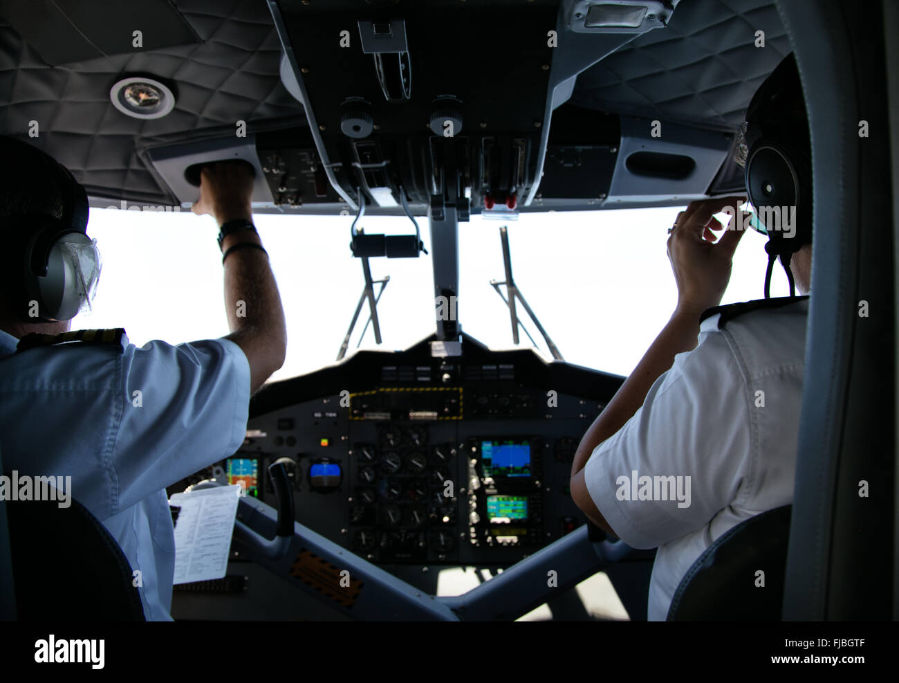 Rear view of pilot and copilot in cockpit of small private aeroplane ...