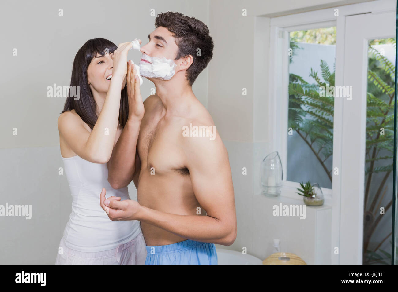 Young woman applying shaving cream on young mans face Stock Photo - Alamy