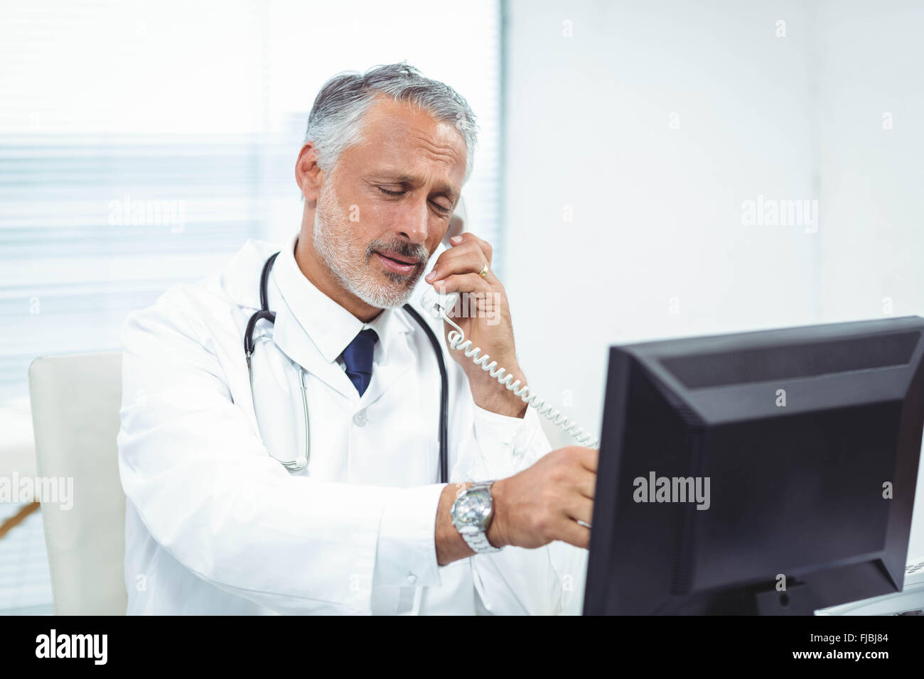 Doctor on phone computer hospital hi-res stock photography and images ...
