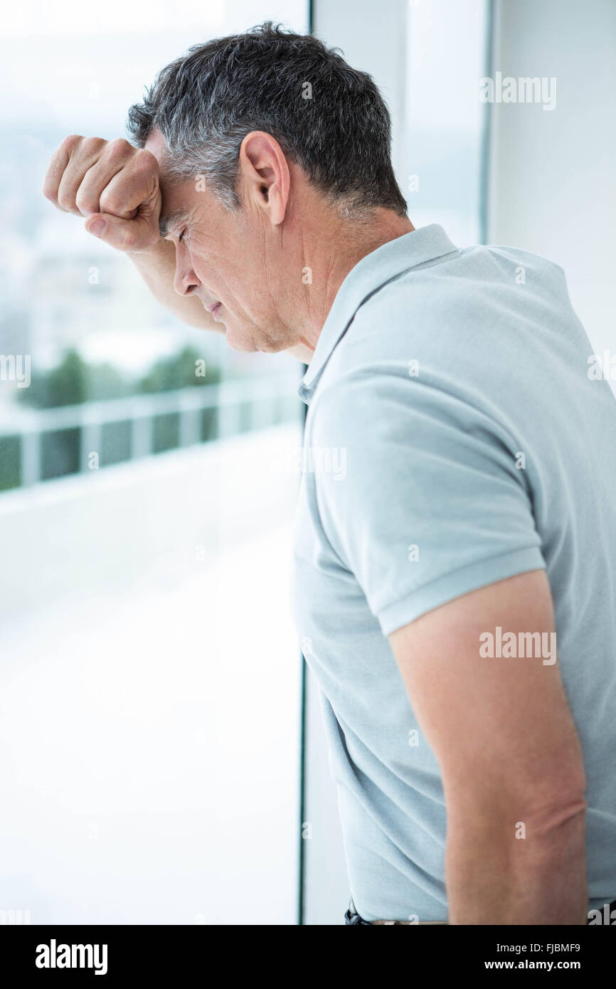 Tensed man leaning on glass window Stock Photo - Alamy