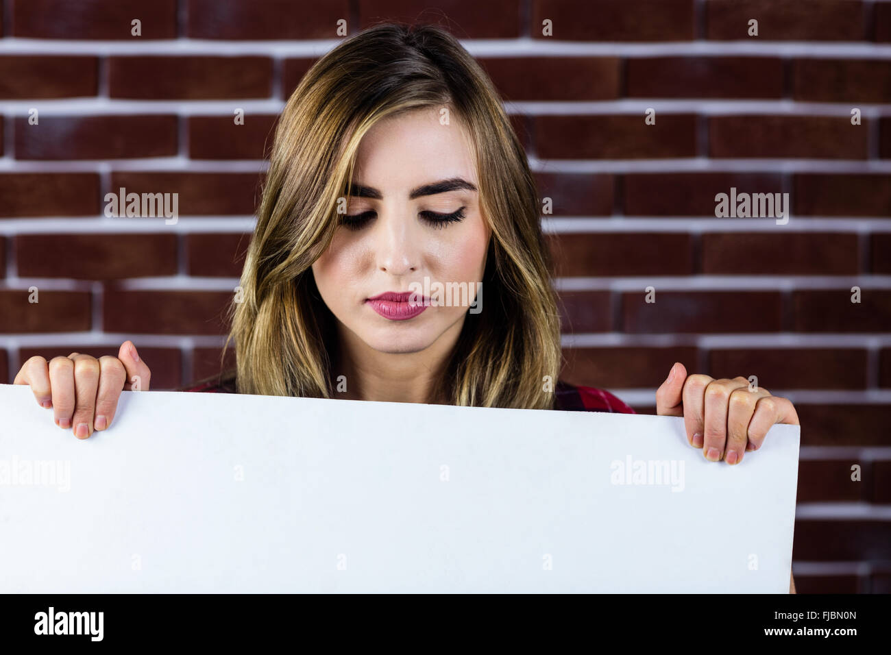 Pretty blonde woman holding a white sign Stock Photo - Alamy