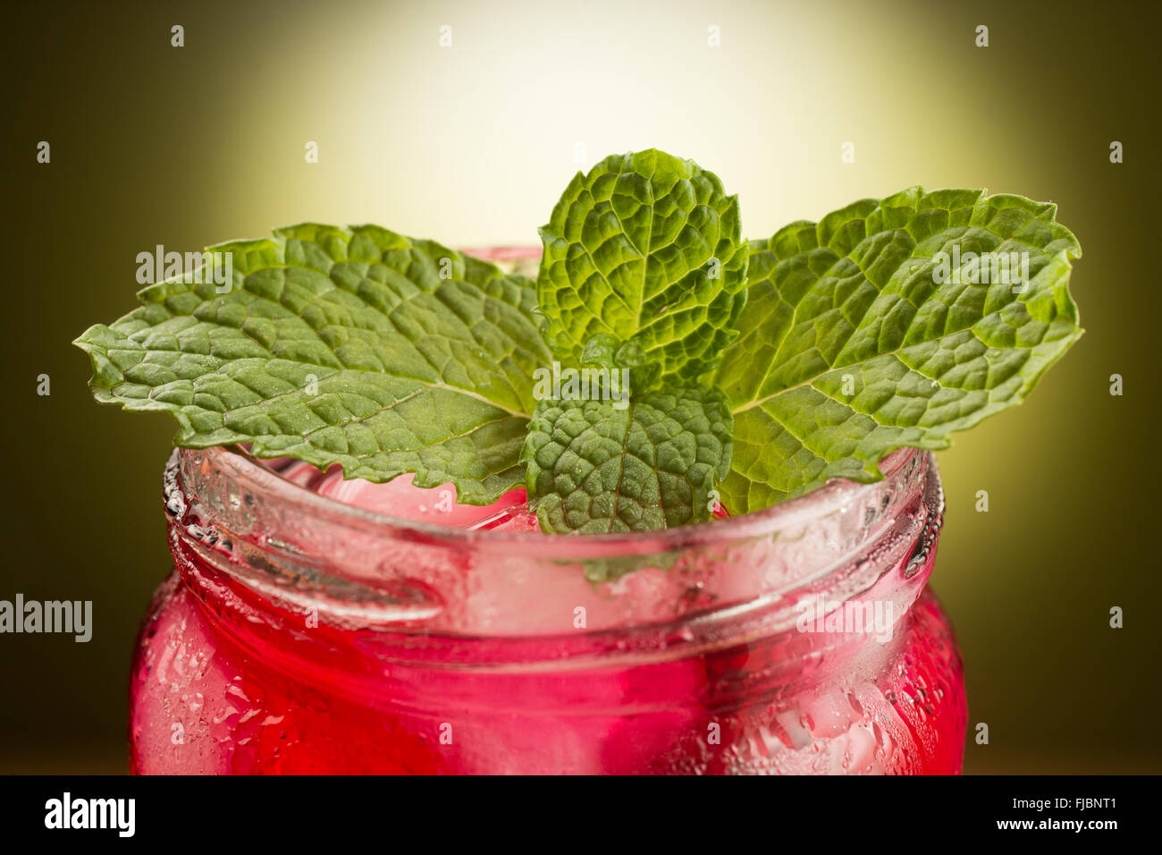 Closeup of mason jar of raspberry juice with mint leaves Stock Photo ...