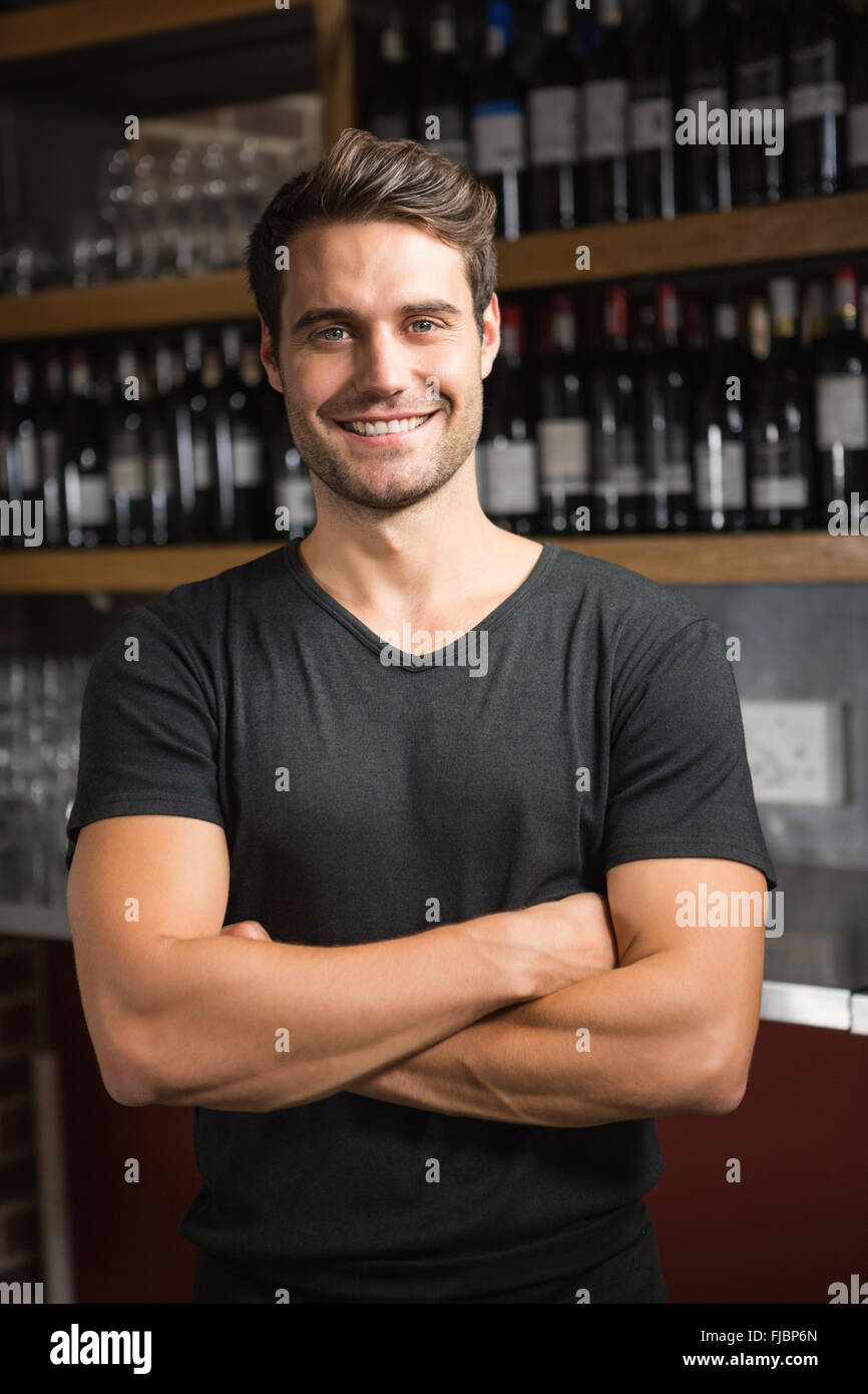 Handsome bar tender standing behind his counter Stock Photo - Alamy